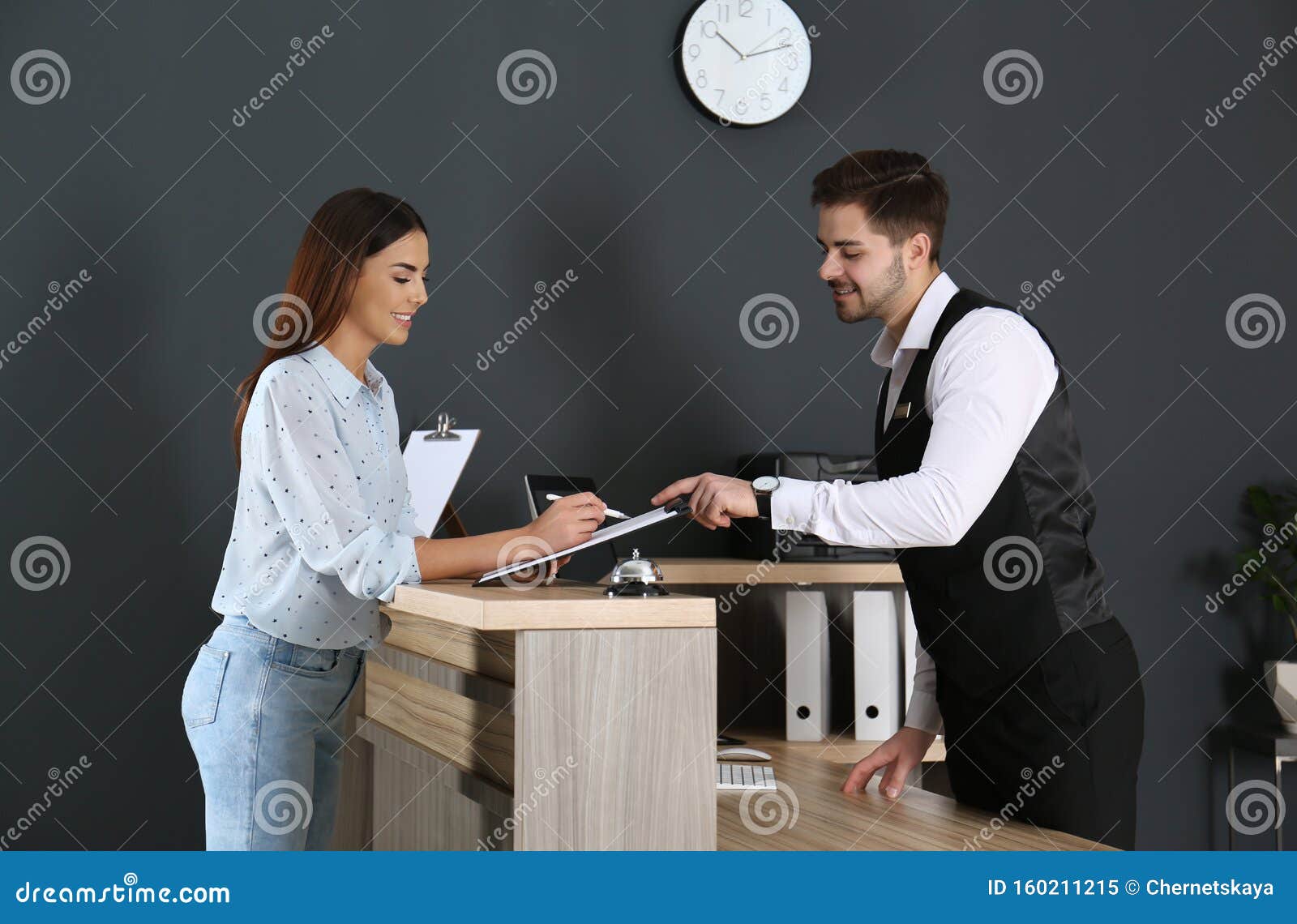 Receptionist Registering Client at Desk Stock Image - Image of guest ...