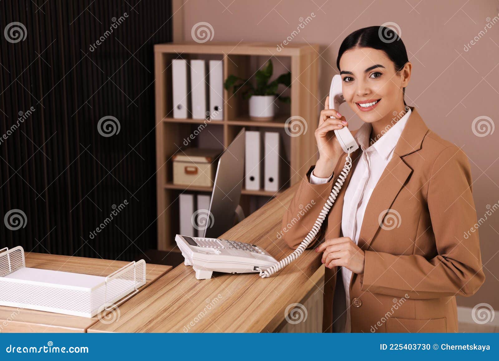 Receptionist Talking on Phone Near Countertop in Office Stock Photo ...