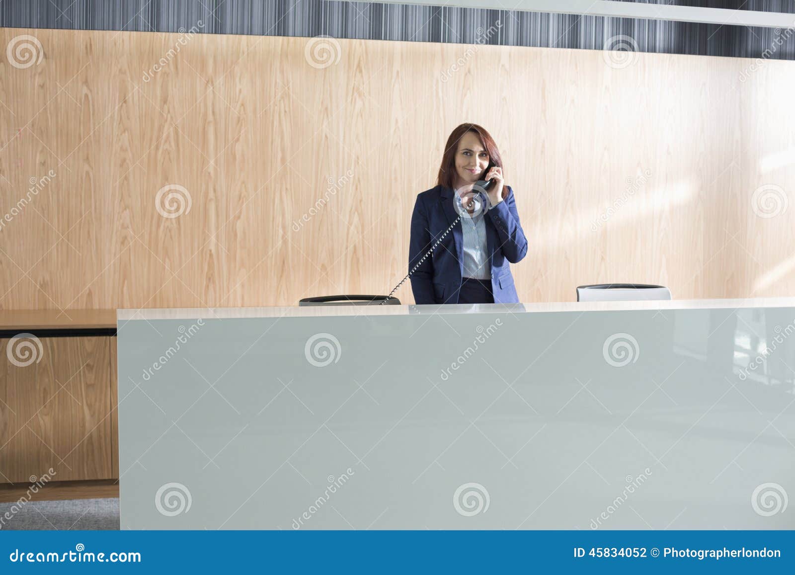 Receptionist Talking on Telephone in Office Stock Photo - Image of ...