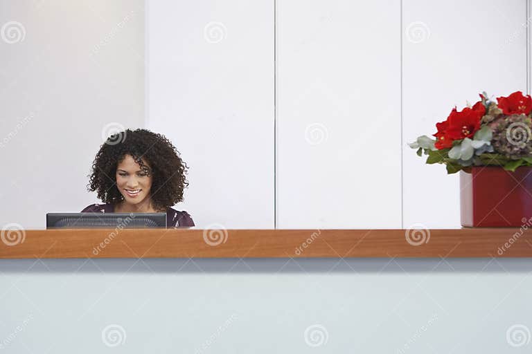 Receptionist Using Computer at Reception Desk Stock Photo - Image of ...