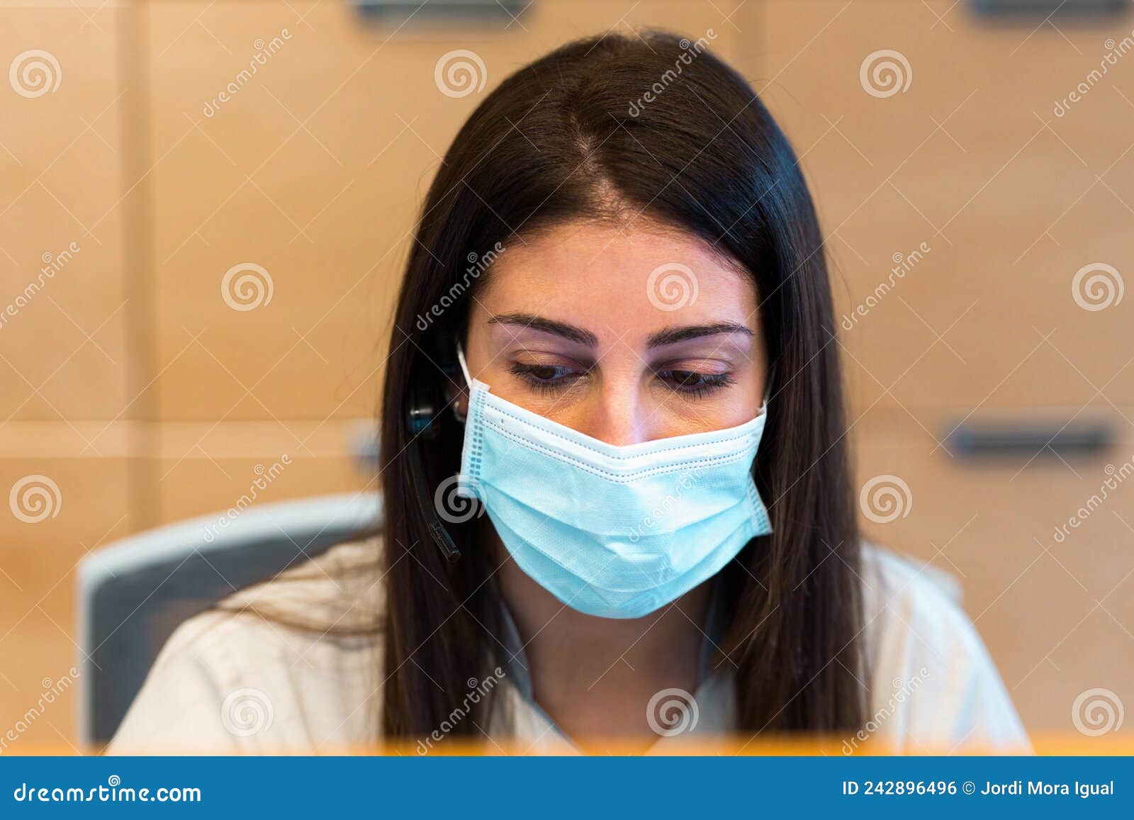 Receptionist Wearing Surgical Face Mask Sitting at Reception while ...
