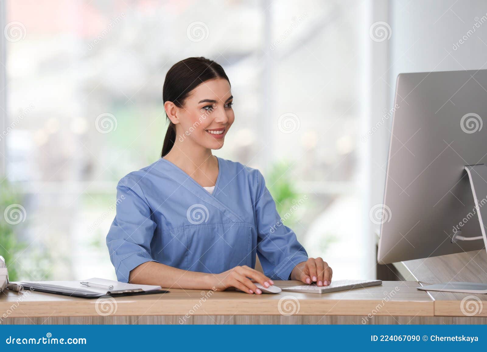 Receptionist Working with Computer at Countertop Stock Photo - Image of ...