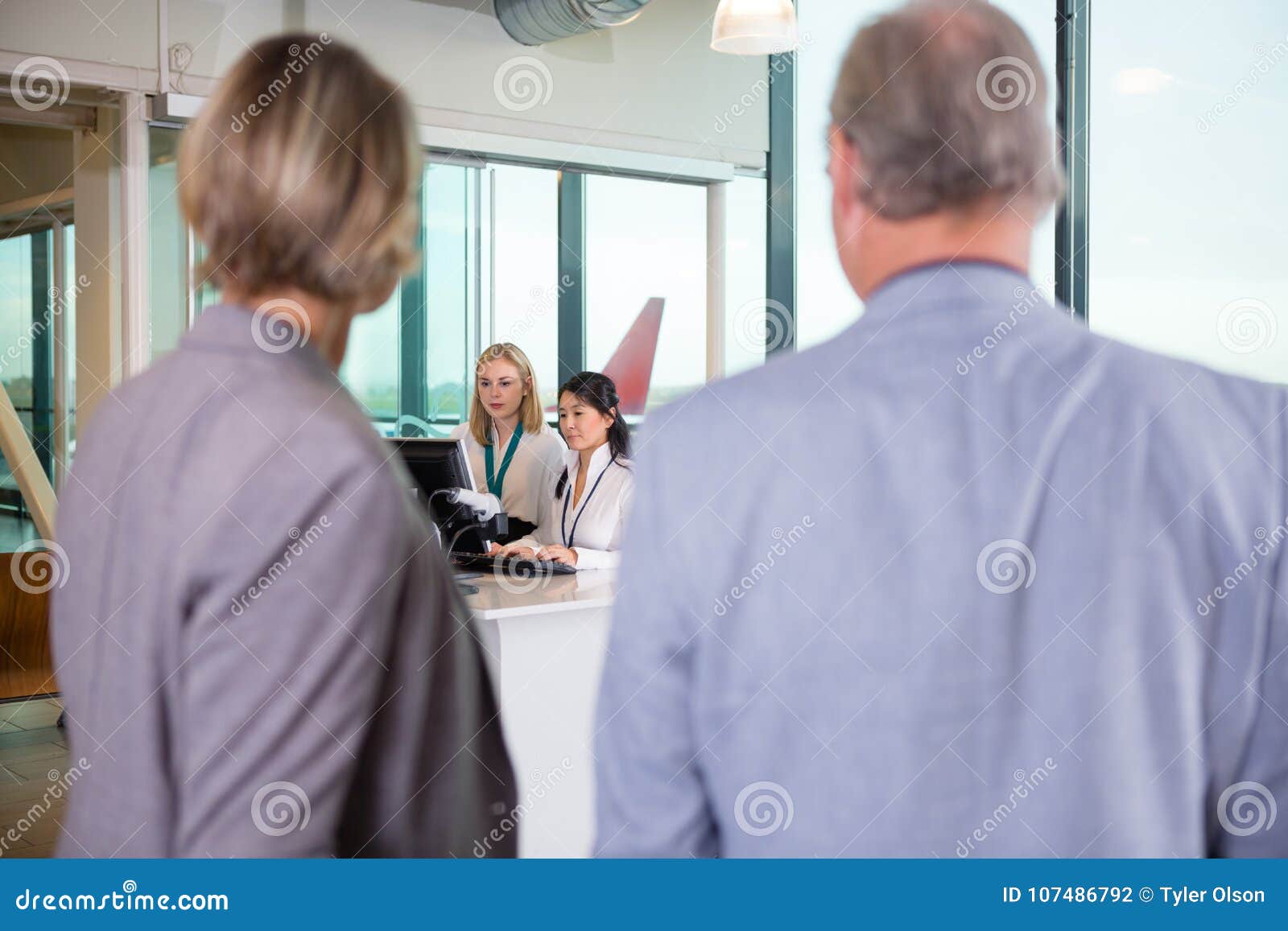 Receptionists Using Computer while Senior Business Couple Waitin Stock ...