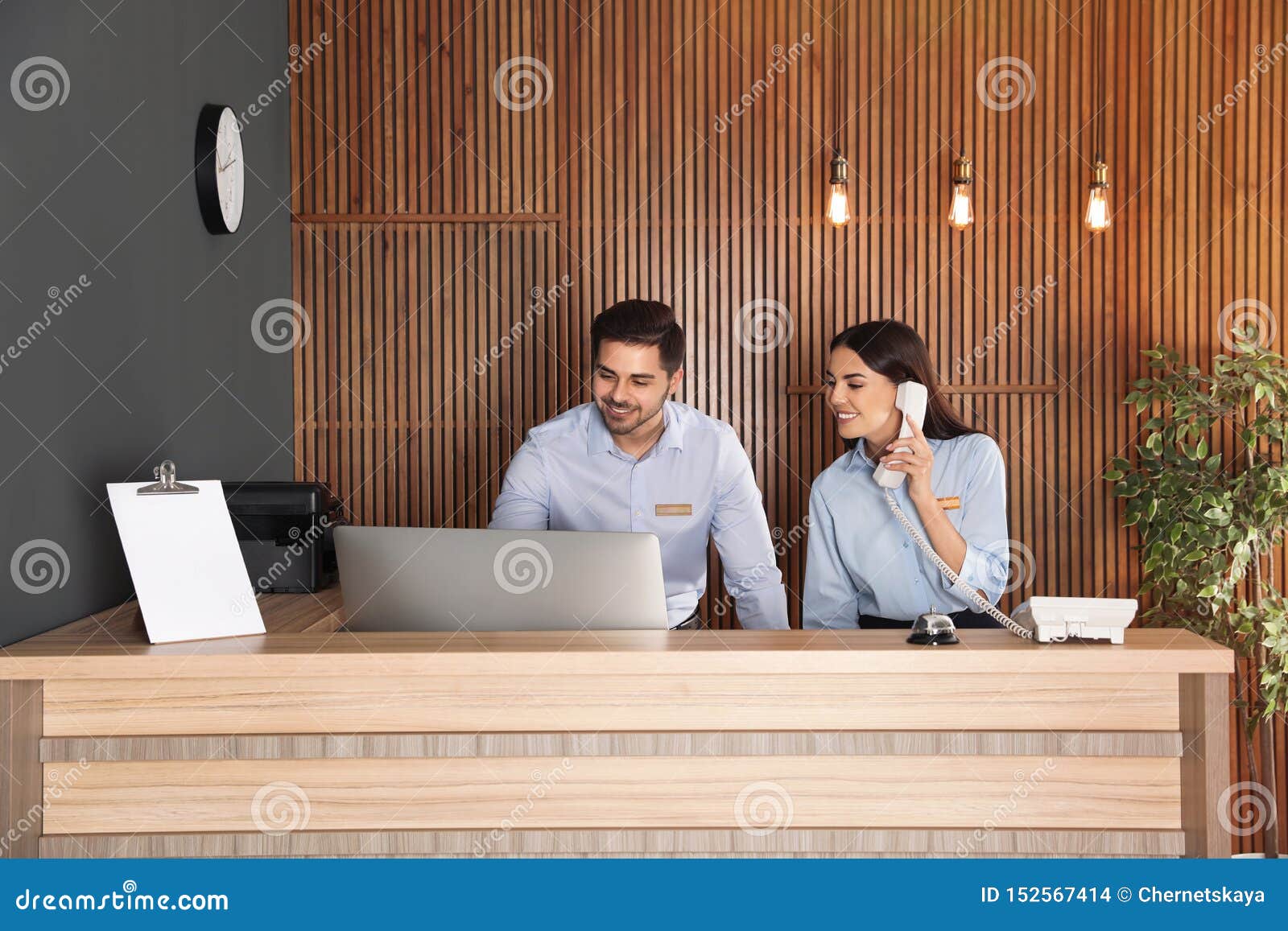 Receptionists Working at Desk in Lobby Stock Photo - Image of people ...