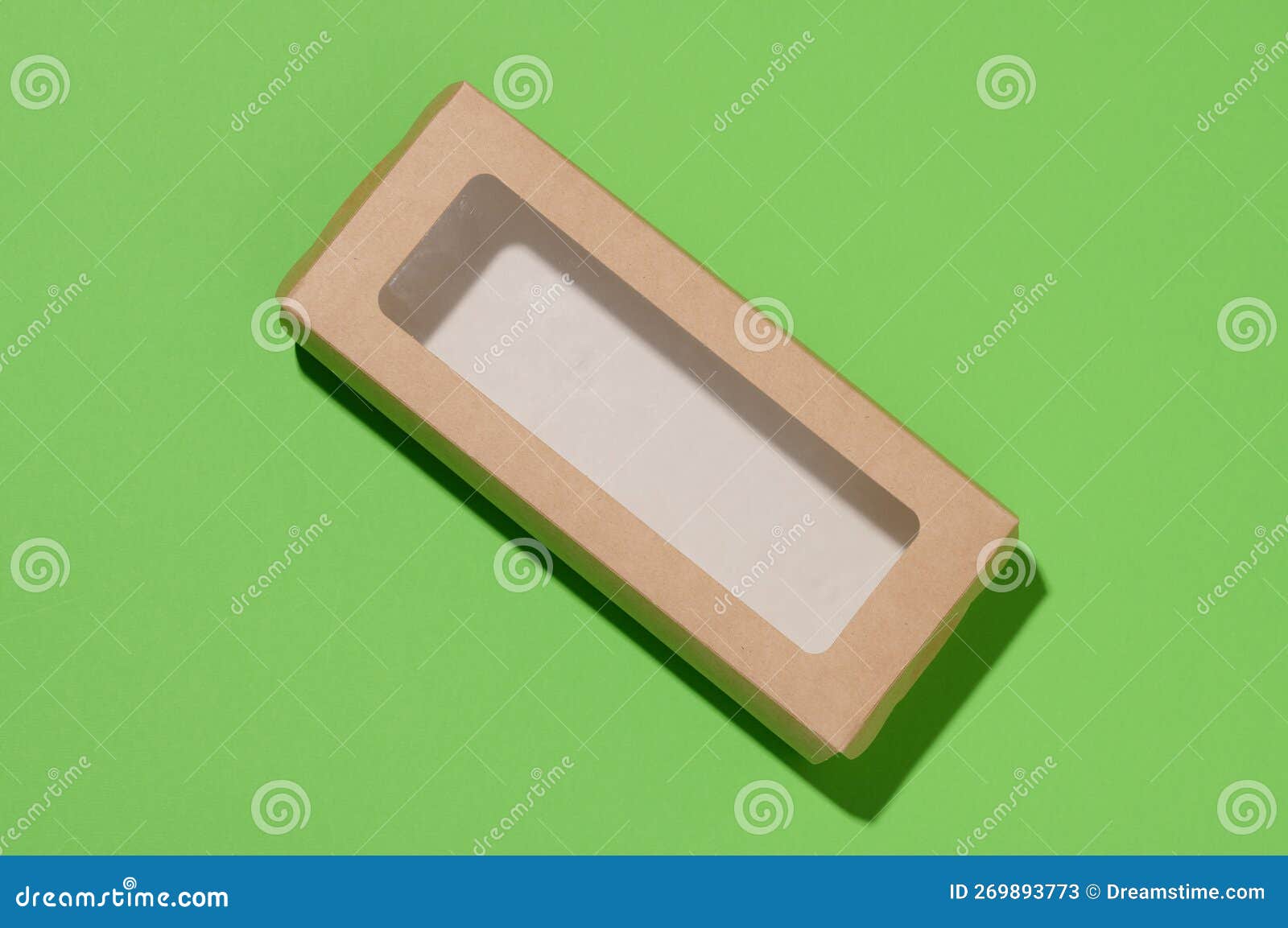 Rectangular Cardboard Box with a Transparent Plastic Lid on a Green ...