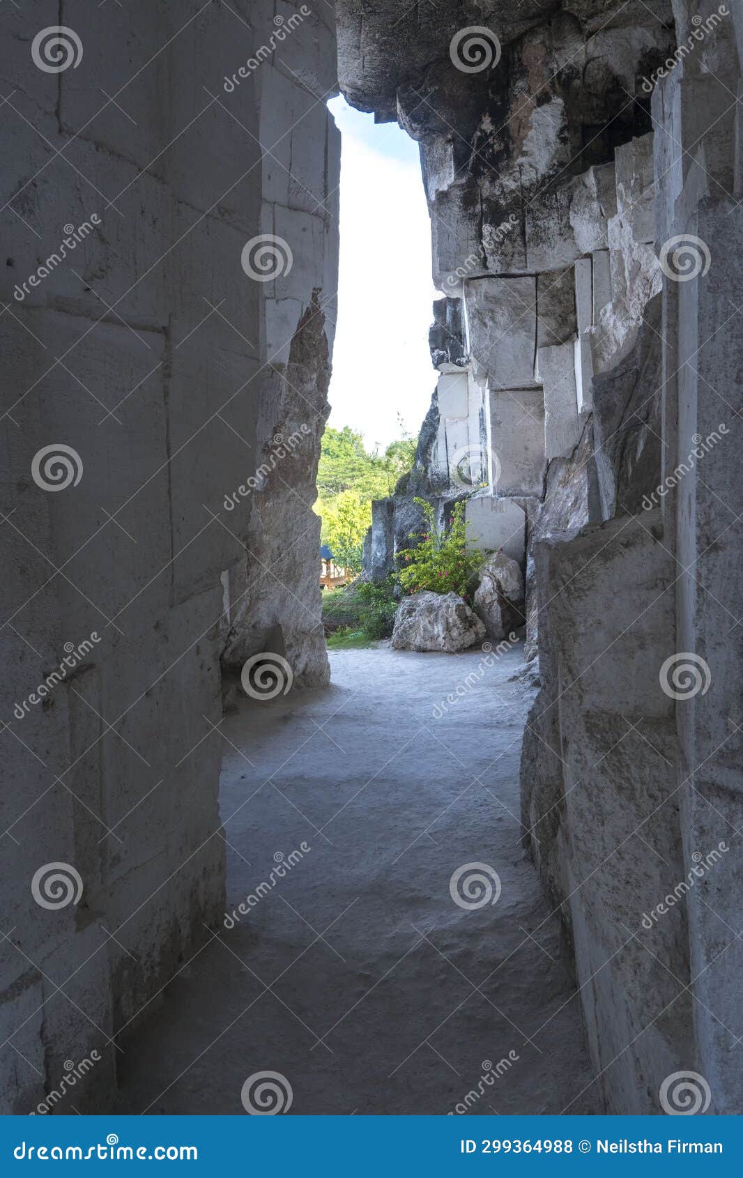A Rectangular Opening in a Dark, Mossy Limestone Cave Frames a Bright ...