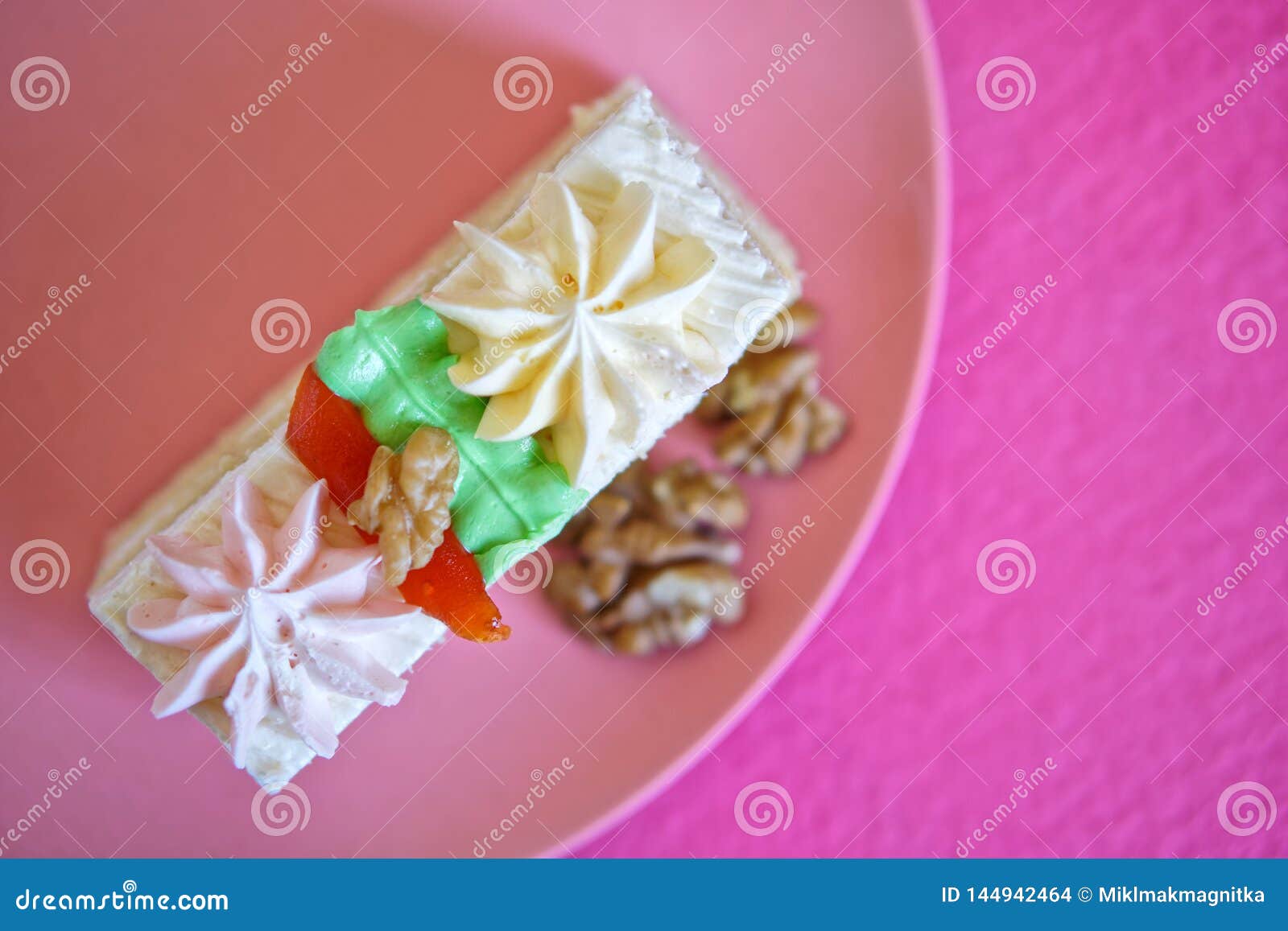 Rectangular Pastry with Protein Cream and Walnuts in a Plate on a Pink ...