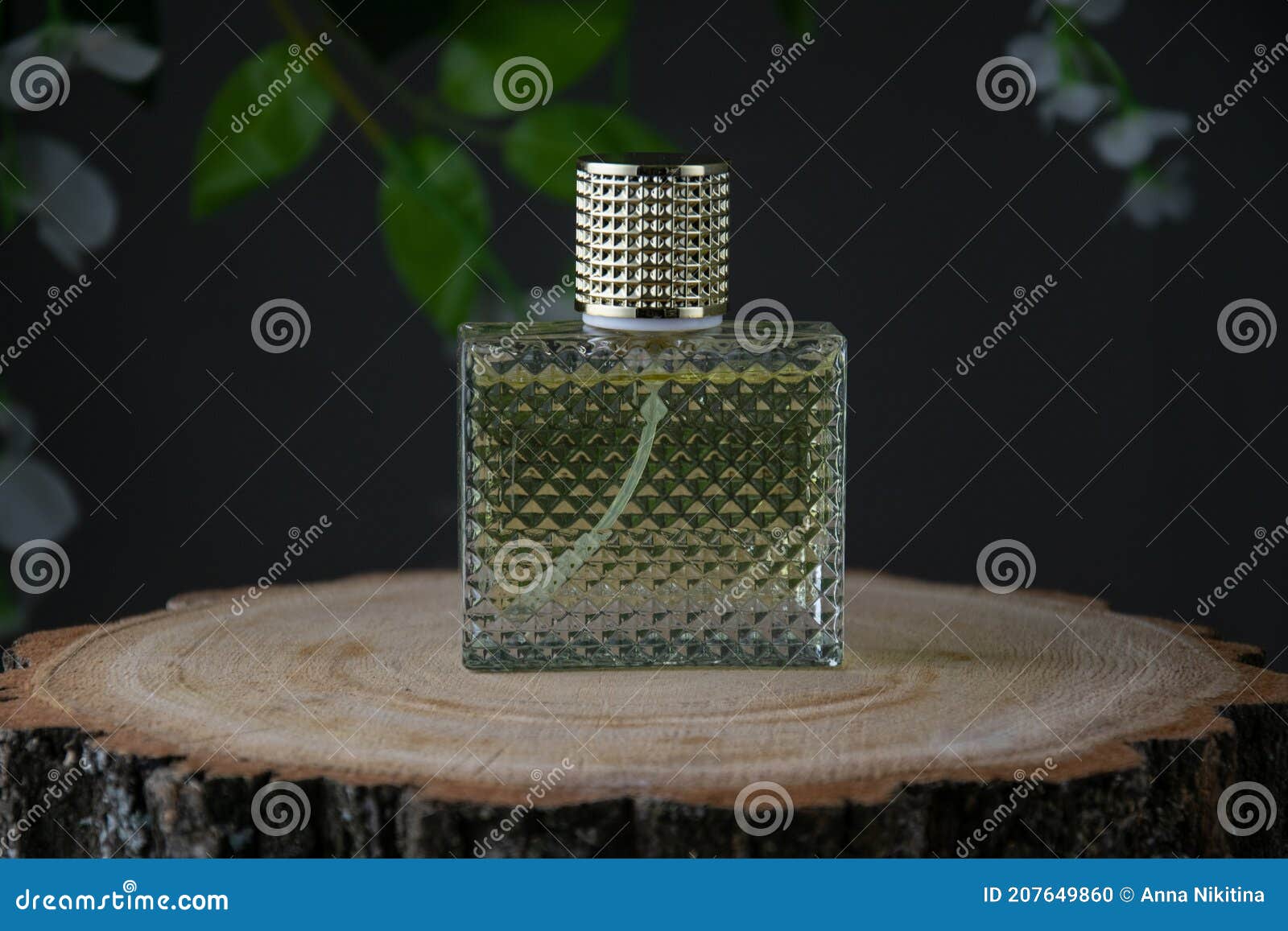 A Rectangular Perfume Bottle on a Slice of Oak. Flowers on the ...
