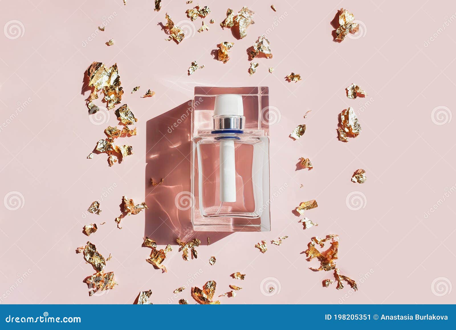 Rectangular Transparent Glass Perfume Bottle and Pieces of Golden Paper ...