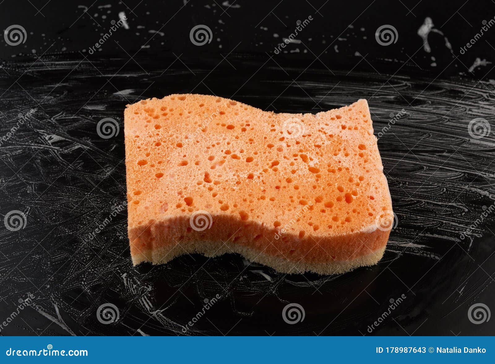 Rectangular Wet Orange Washcloth with White Foam on a Black Background ...