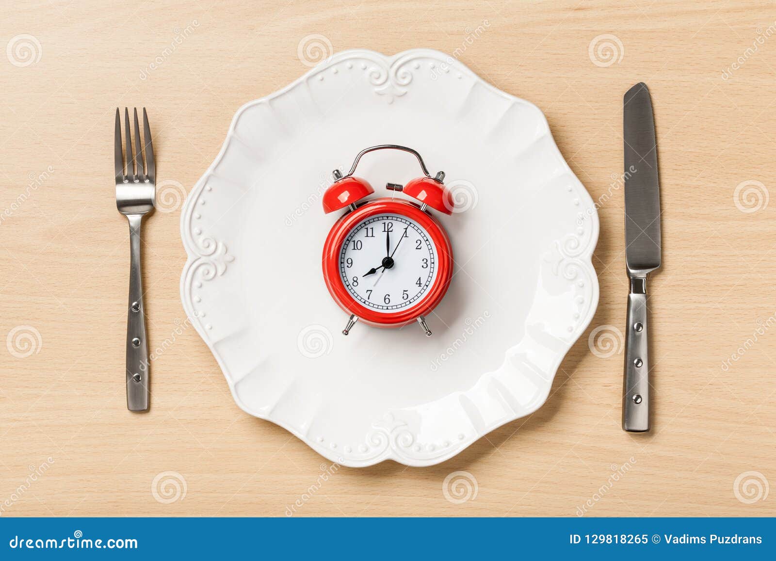 Red Alarm Clock on a Plate, Fork an Knife on a Table Stock Image ...