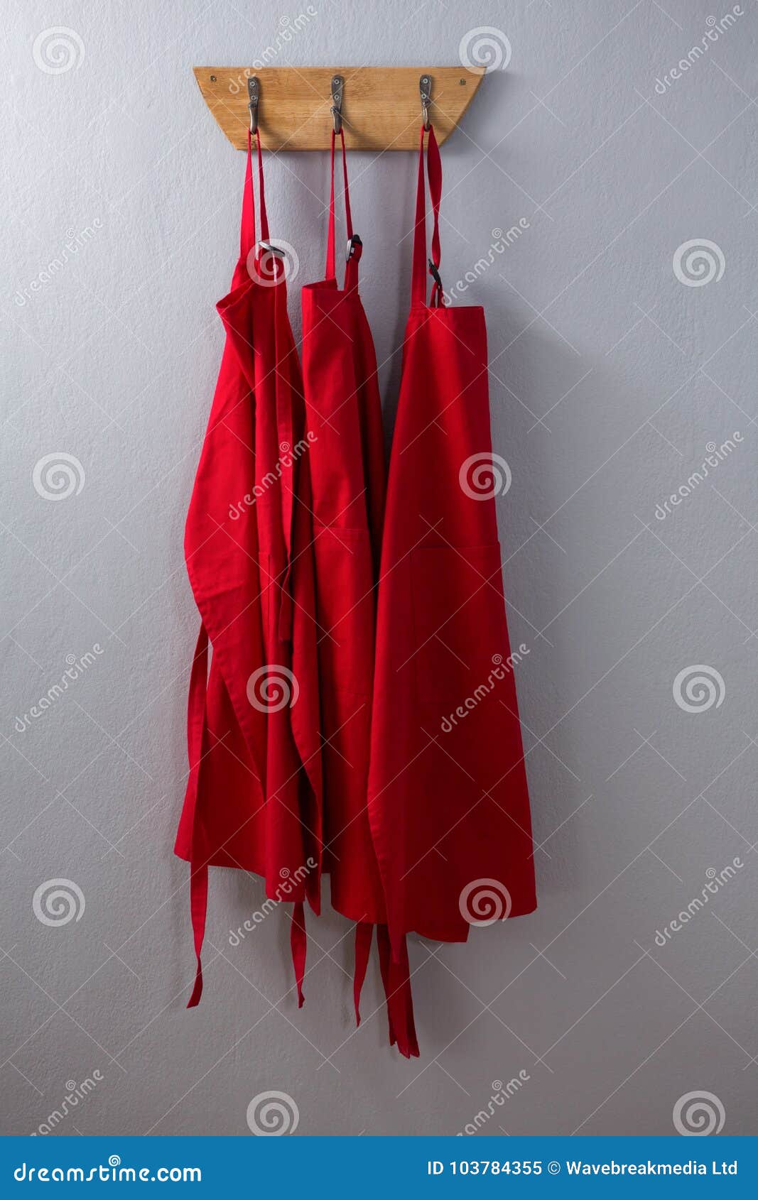 Red aprons hanging on hook stock image. Image of support - 103784355