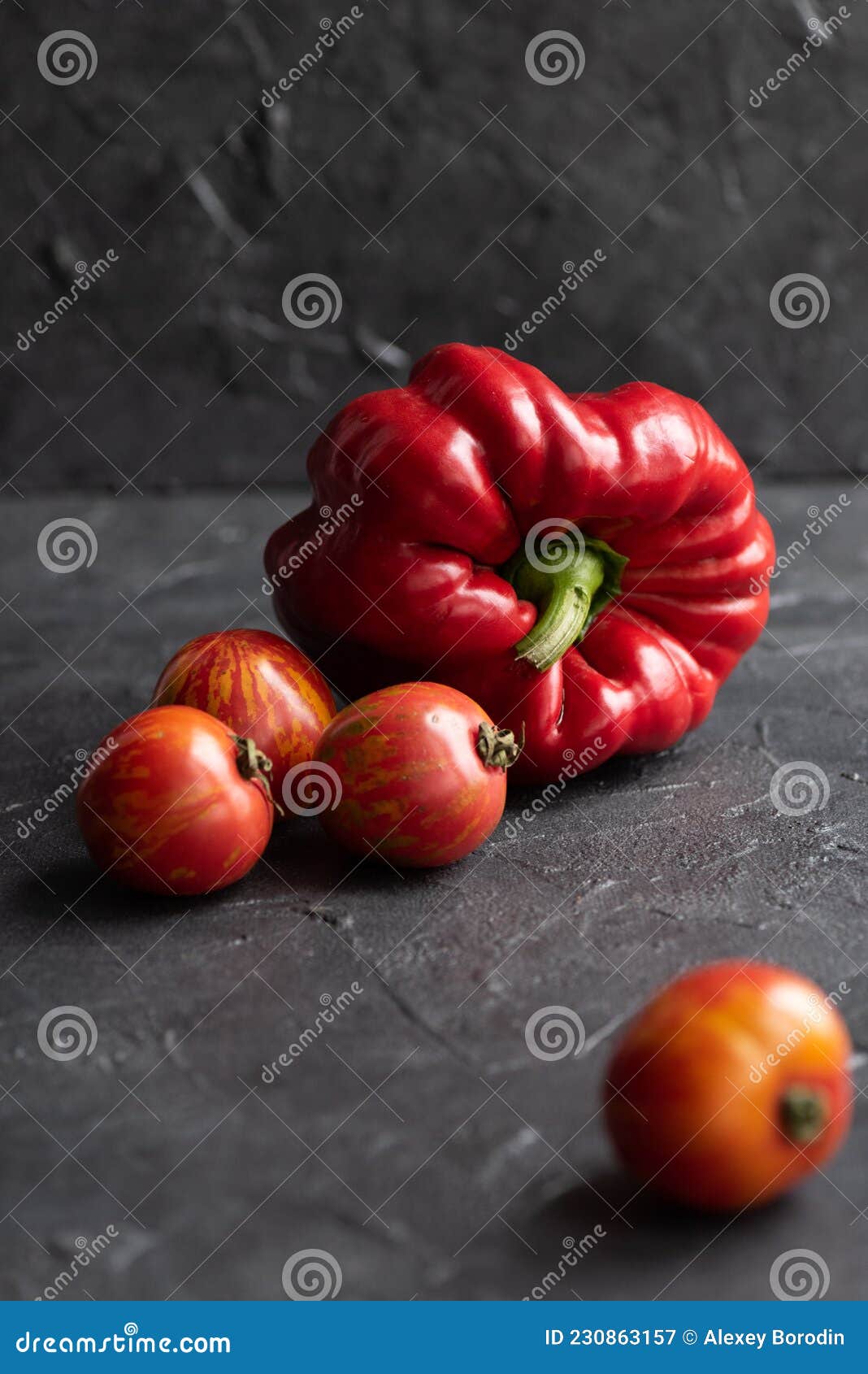 Red Bell Pepper with Stripped Red Tomatoes on Dark Plaster Background ...