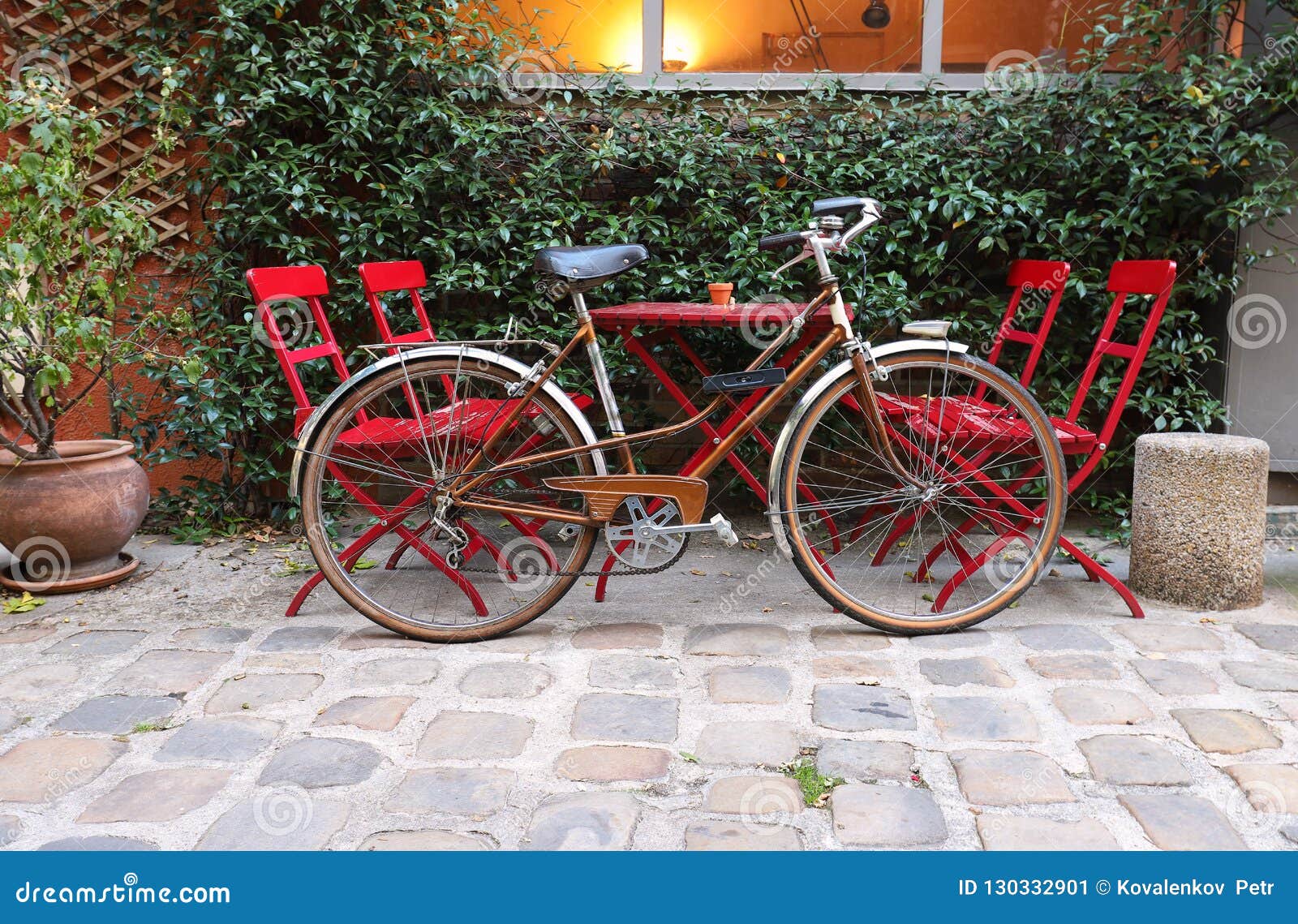 Red Bike Standing in Front of Garden Table with Chairs. Stock Image ...
