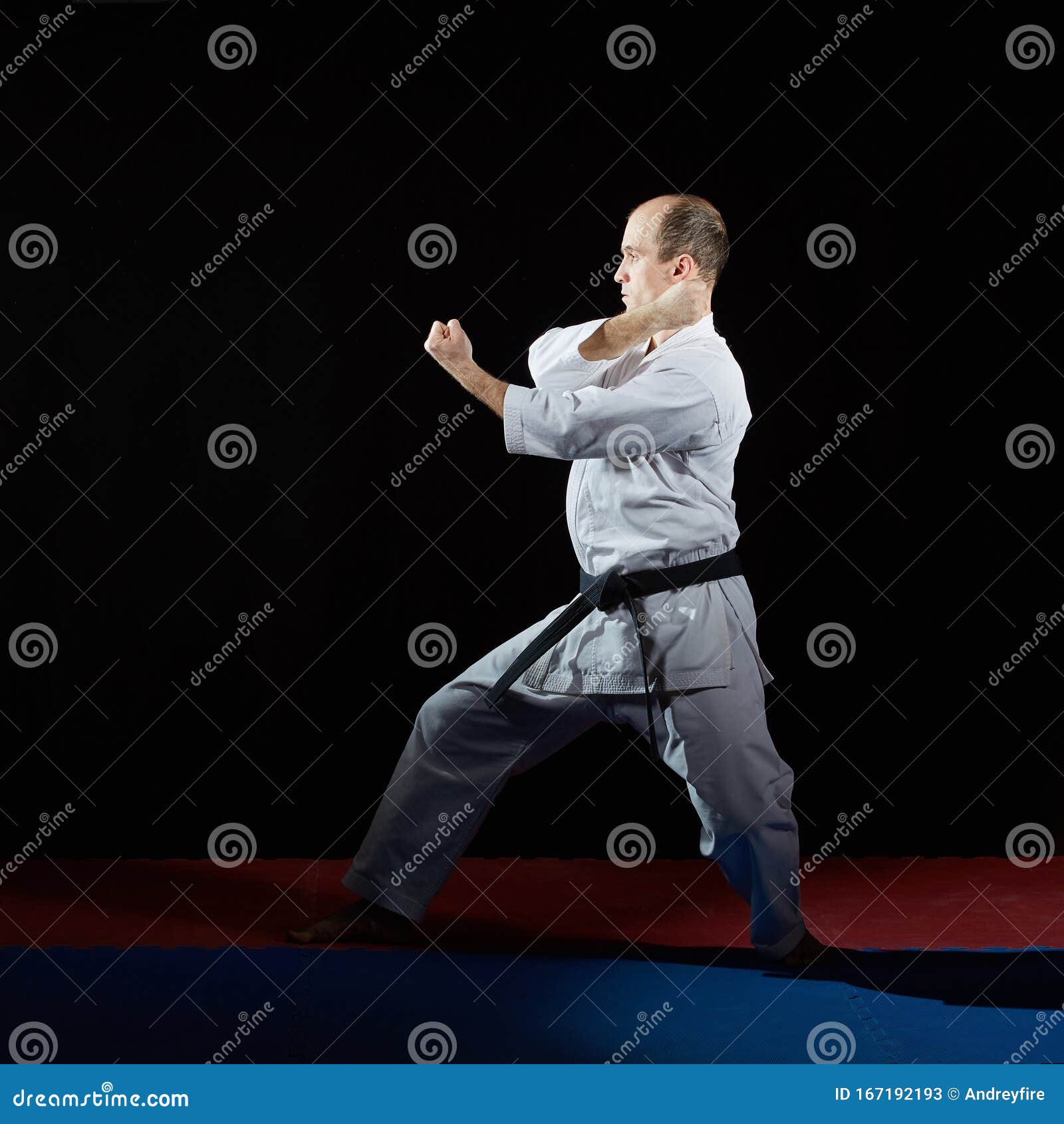 On Red and Blue Tatami Active Athlete Trains Formal Karate Exercises ...