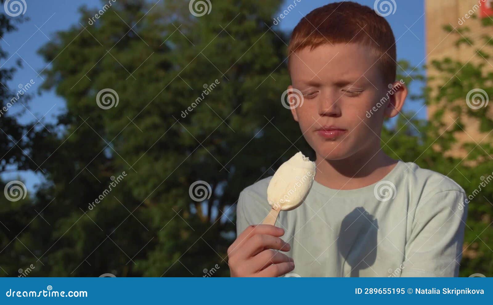 Red boy eating popsicle stock video. Video of urban - 289655195