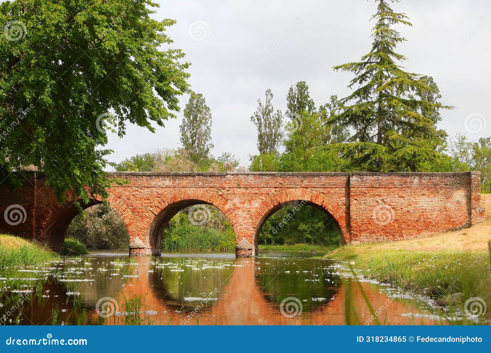 Red Brick Bridge with Visible Masonry and the Reflection of Its Three ...