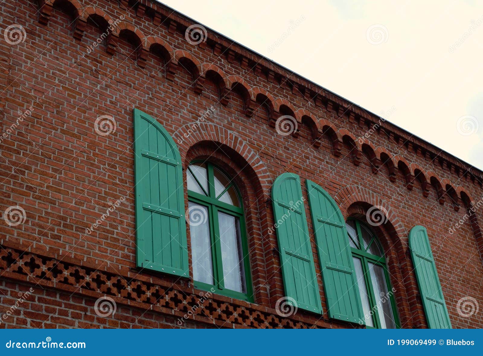 Red Brick Facade with Two Windows with Green Shutters Stock Image ...