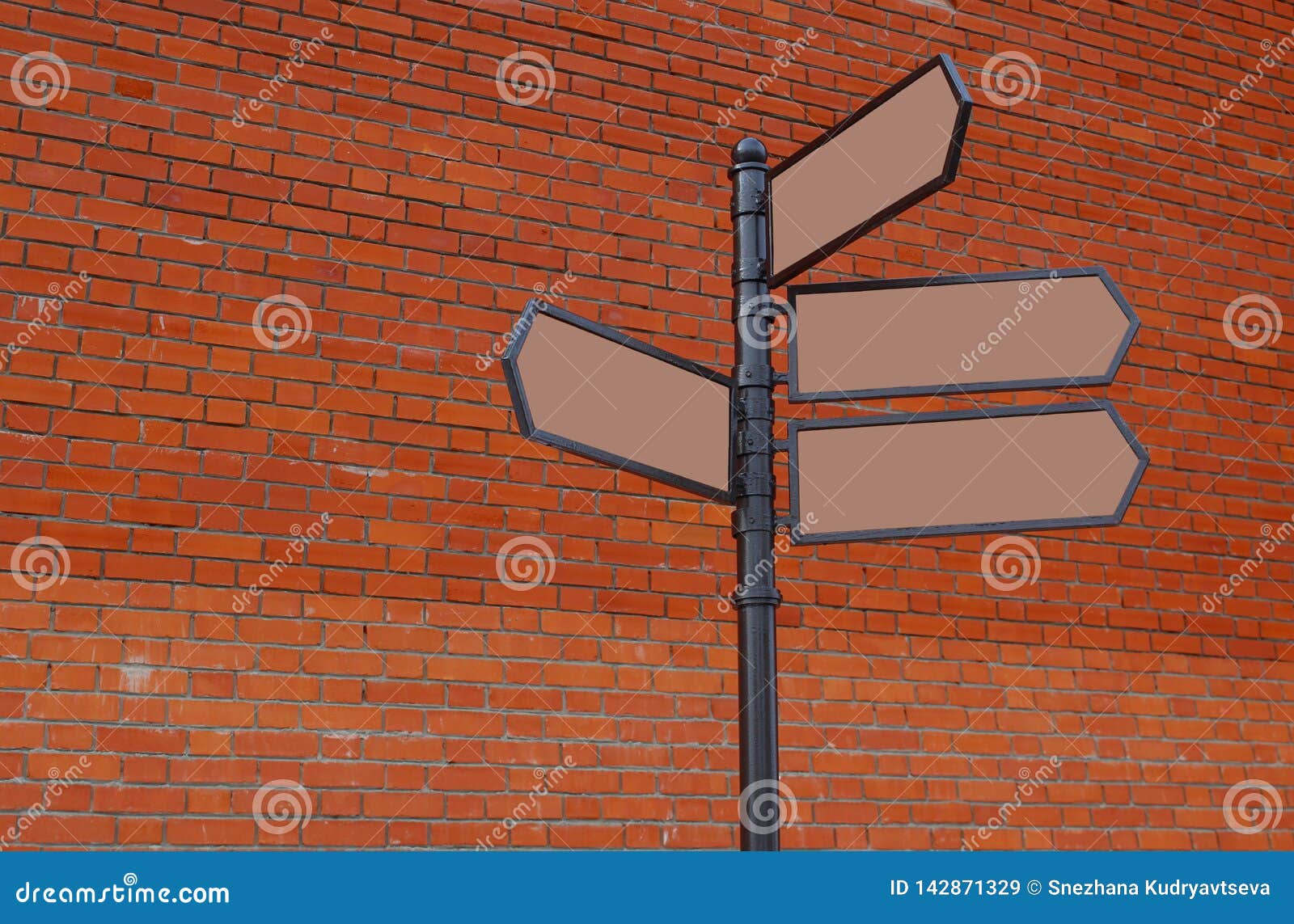 At the Red Brick Wall is an Iron Column with Arrows Stock Image - Image ...