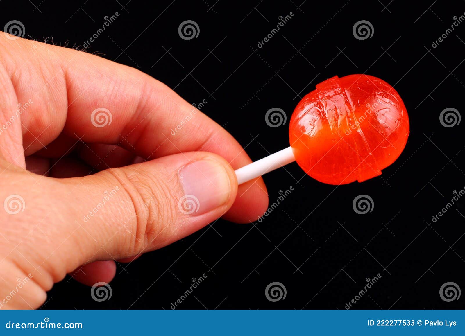 Red Candy in Hand on a Stick on Black Background Stock Image - Image of ...