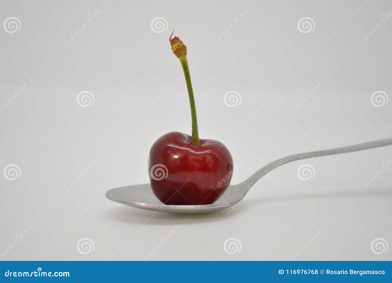 Red cherry on metal spoon stock photo. Image of food - 116976768