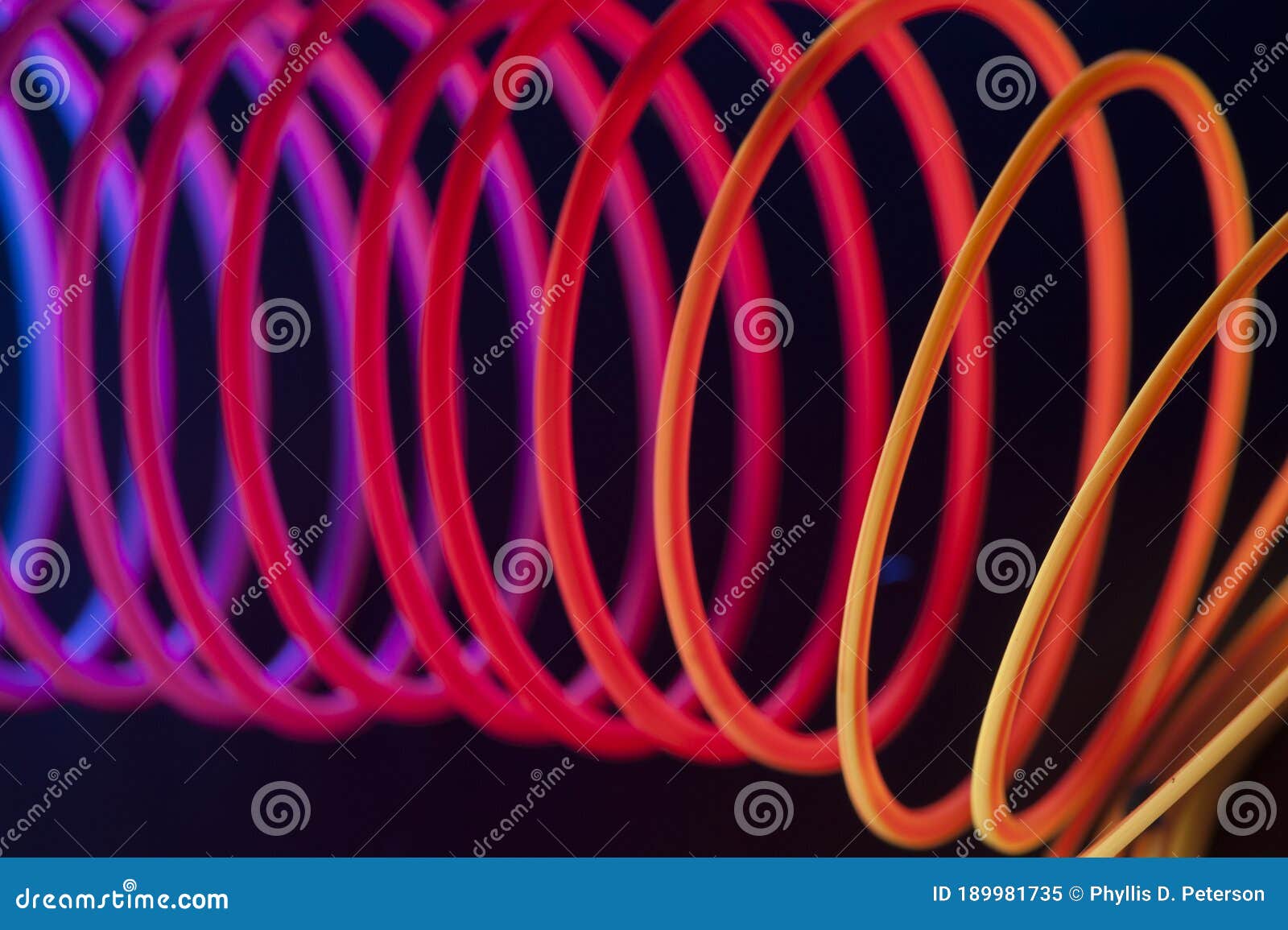 Red Circular Objects are Lit with Fluorescent Colors Against a Deep ...