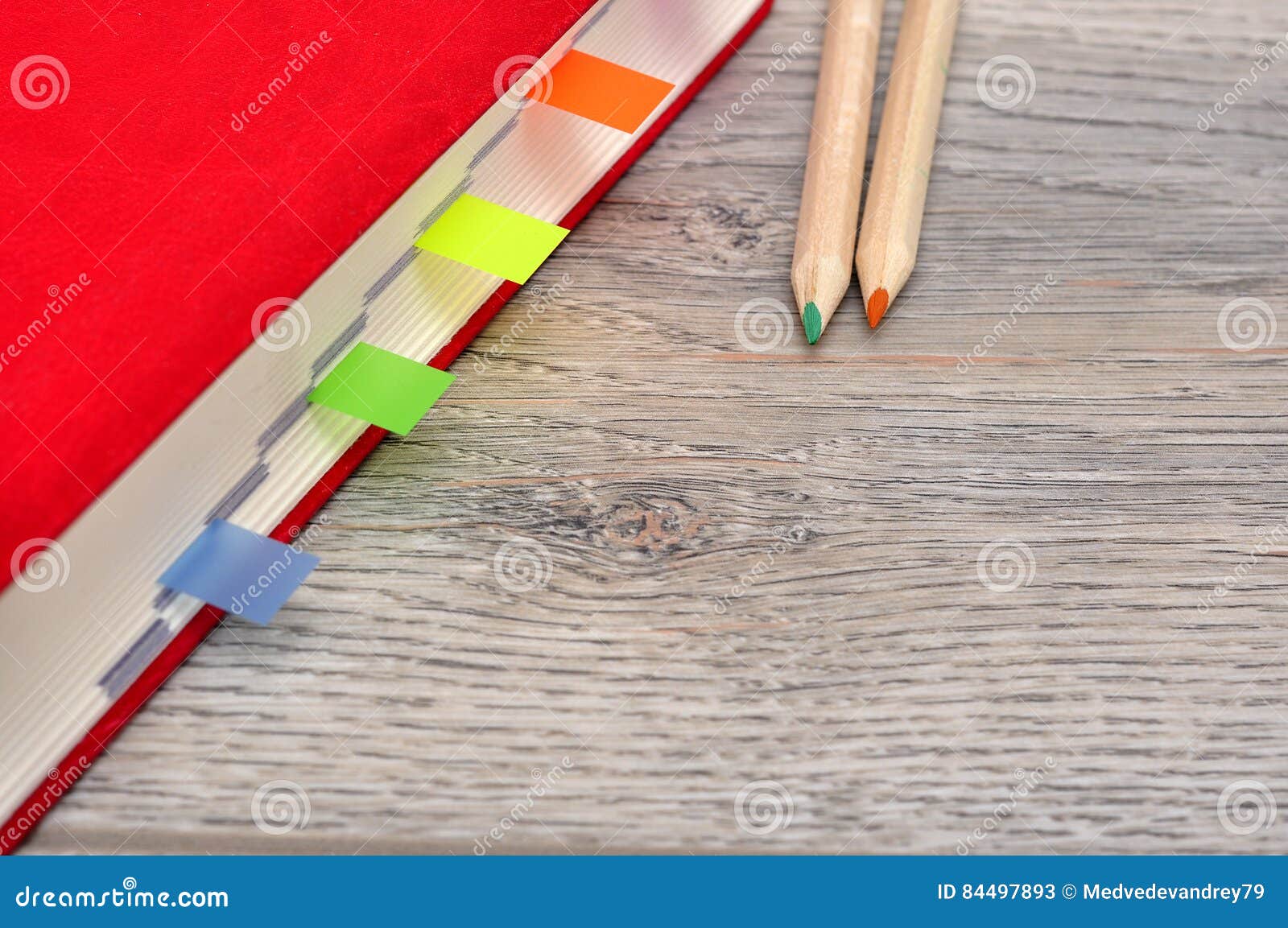 Red Diary Notebook and Colored Pencils on the Desk Wood Texture. Stock ...