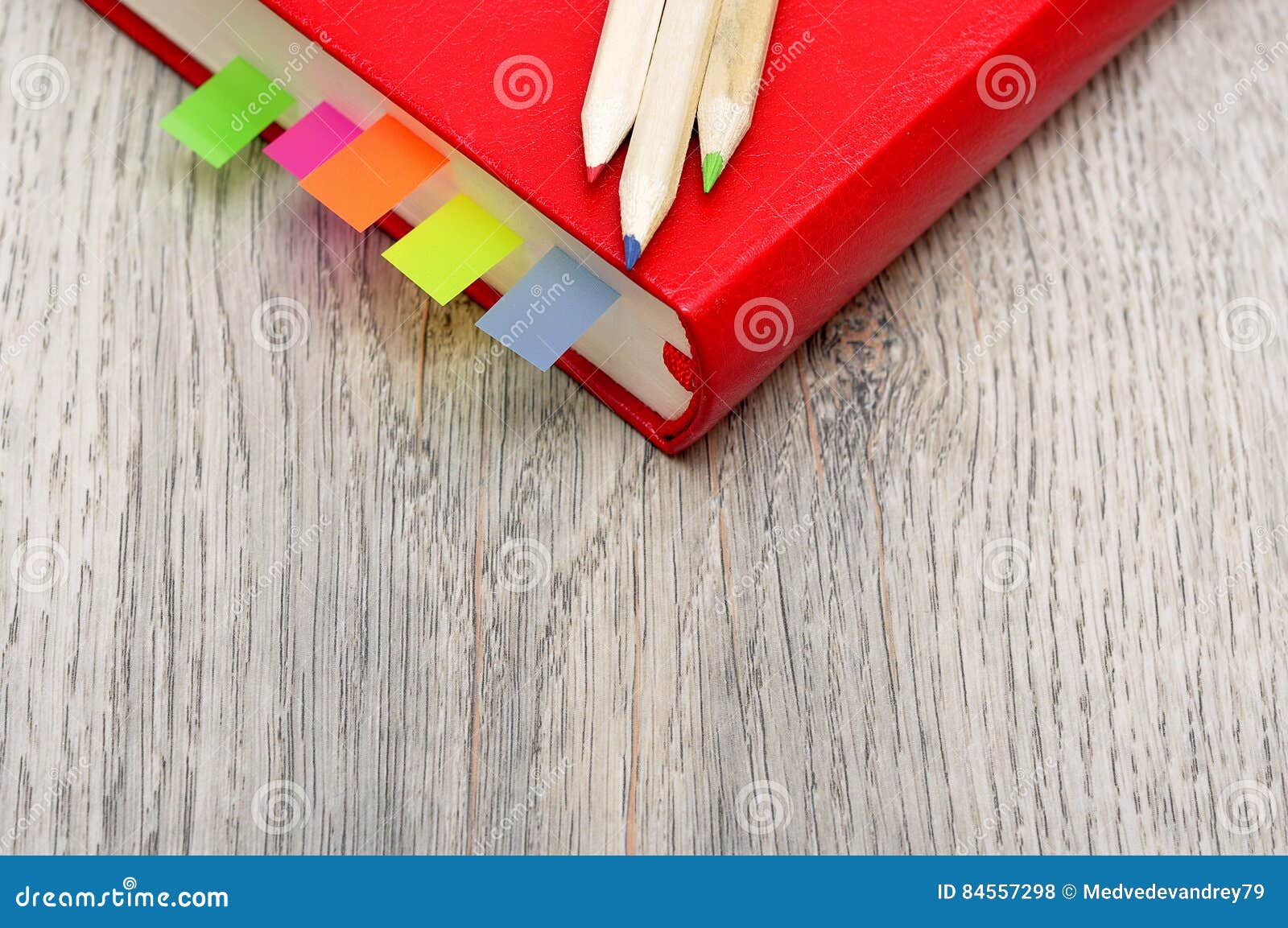 Red Diary Notebook and Colored Pencils on the Desk Wood Texture. Stock ...