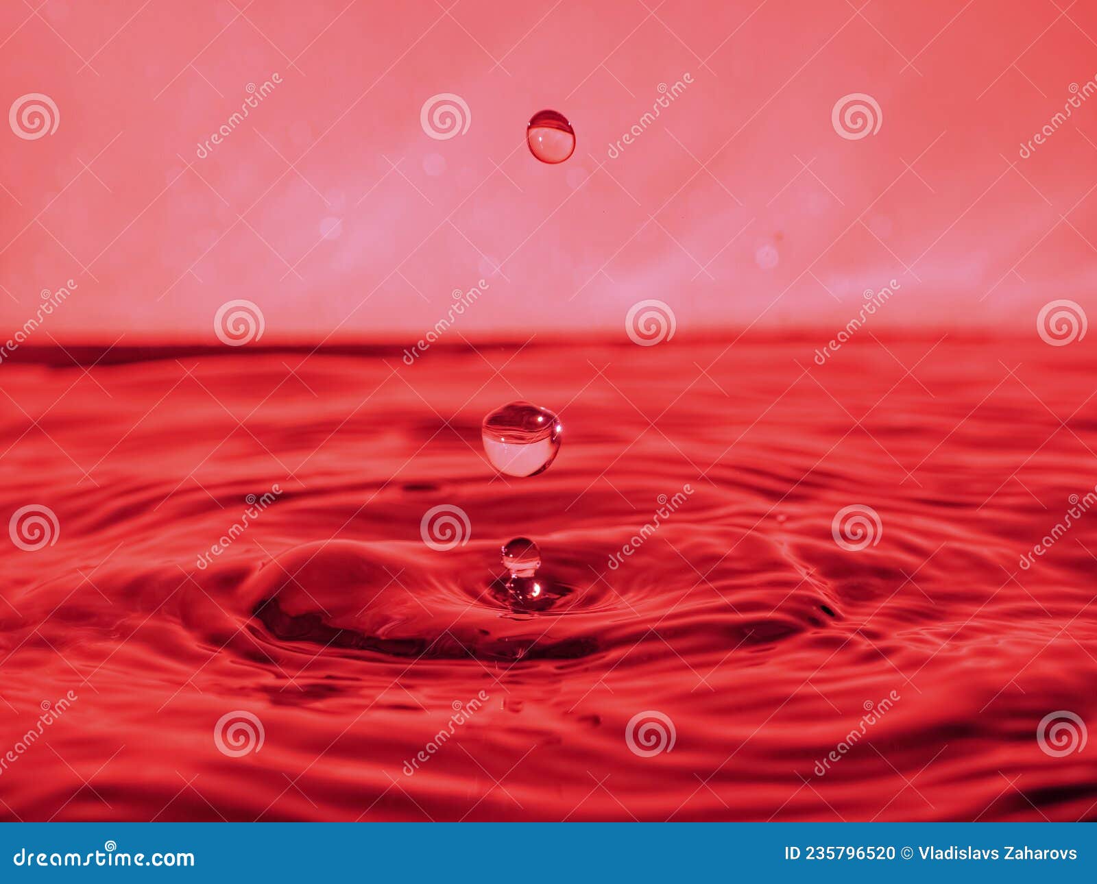 A Red Drop Drips into the Water and Creates Splashes of Different ...