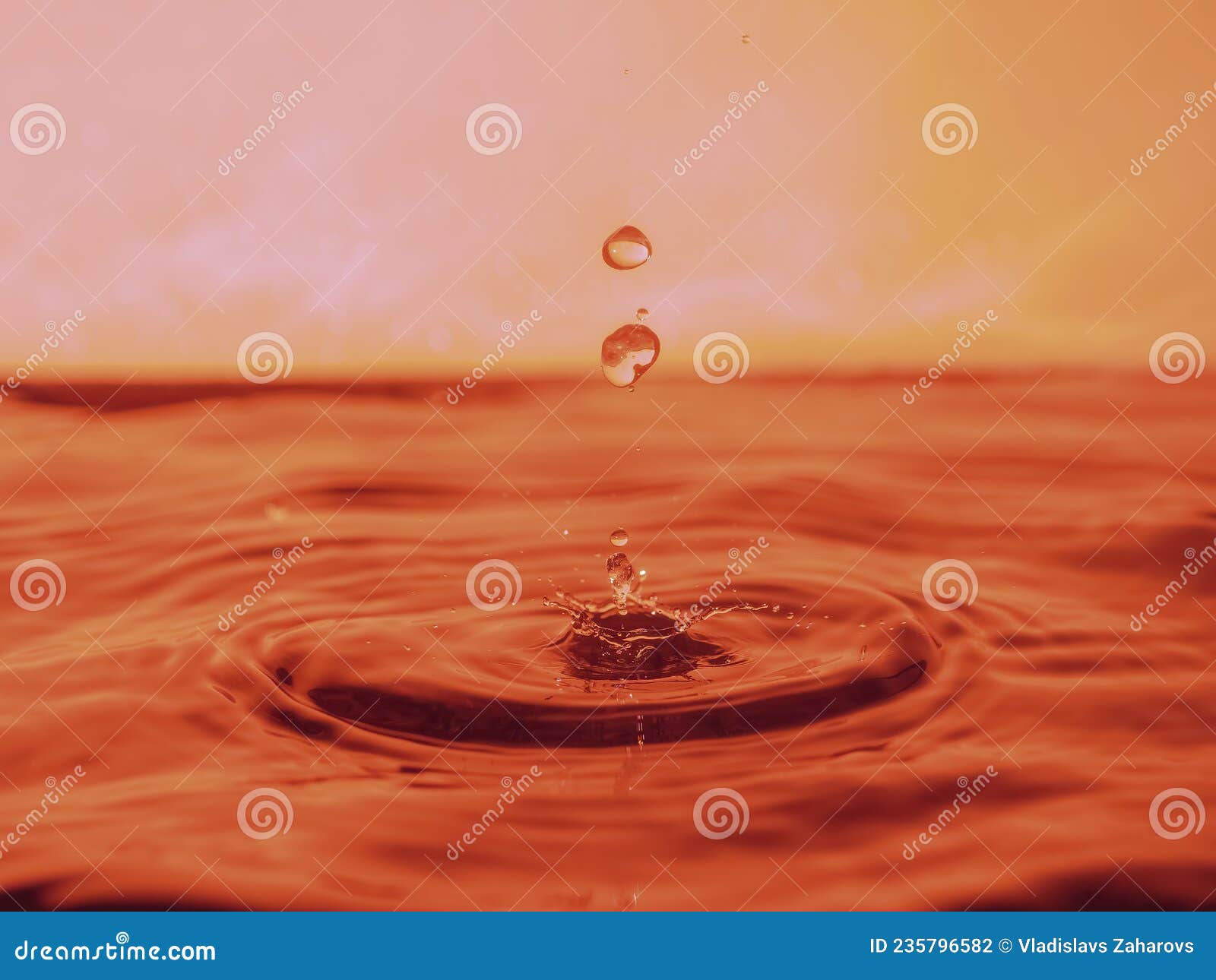 A Red Drop Drips into the Water and Creates Splashes of Different ...