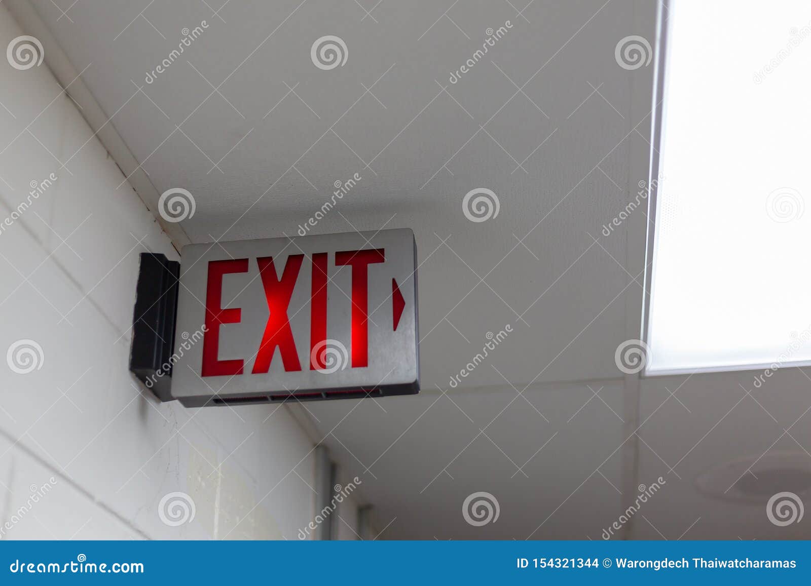 Red Emergency Exit Sign in the Dark Room. Illuminated Office Exit Sign ...