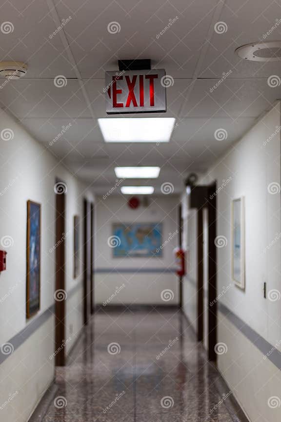 Red Emergency Exit Sign in the Dark Room. Illuminated Office Exit Sign ...