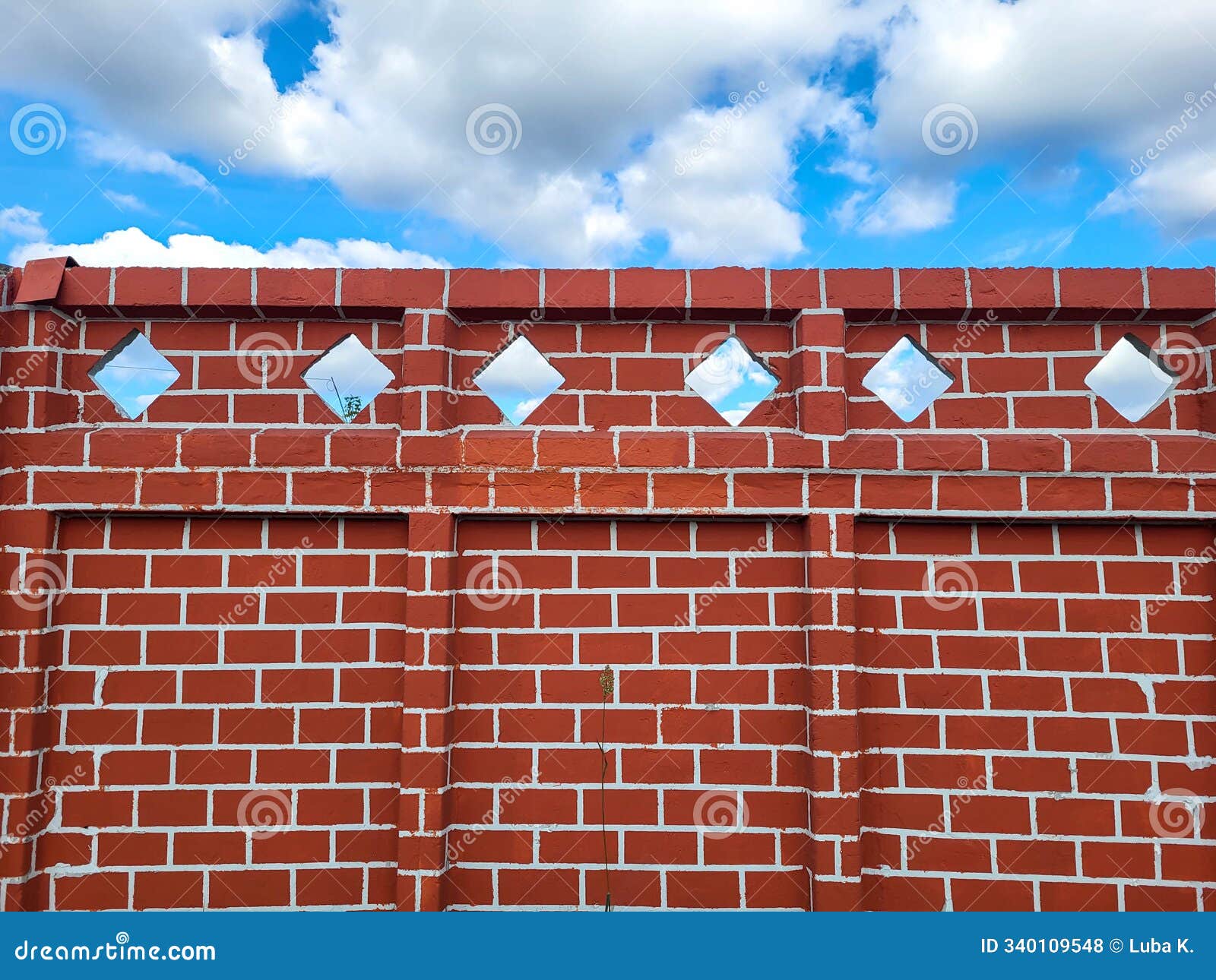 A Red Fence with Painted Bricks and Diamond Shaped Holes. Stock Photo ...