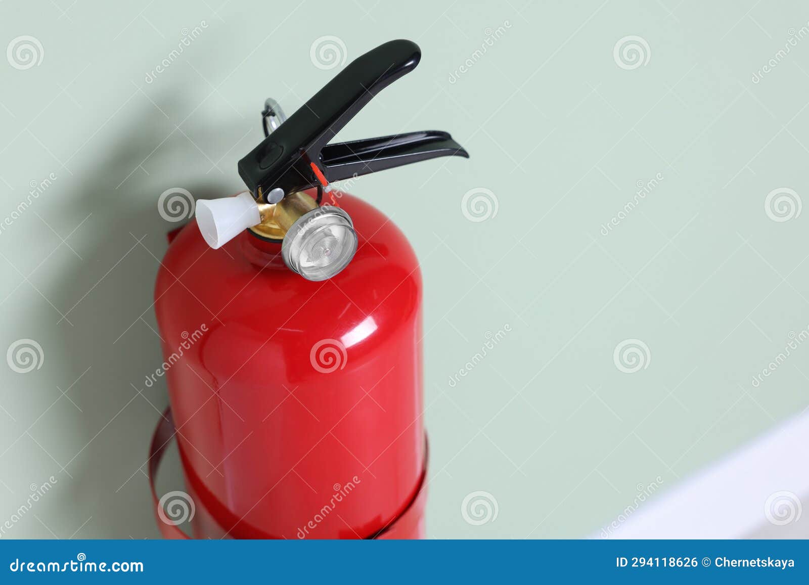 Red Fire Extinguisher on Light Green Wall, Closeup. Space for Text ...