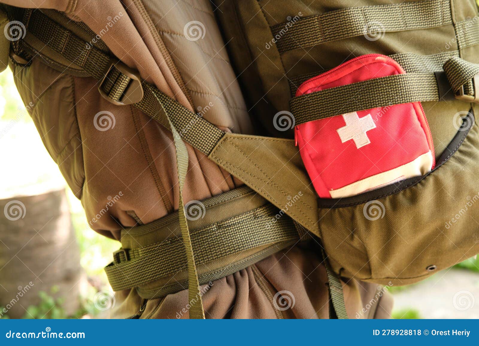 A Red First Aid Kit with a White Cross in the Pocket of a Tactical ...