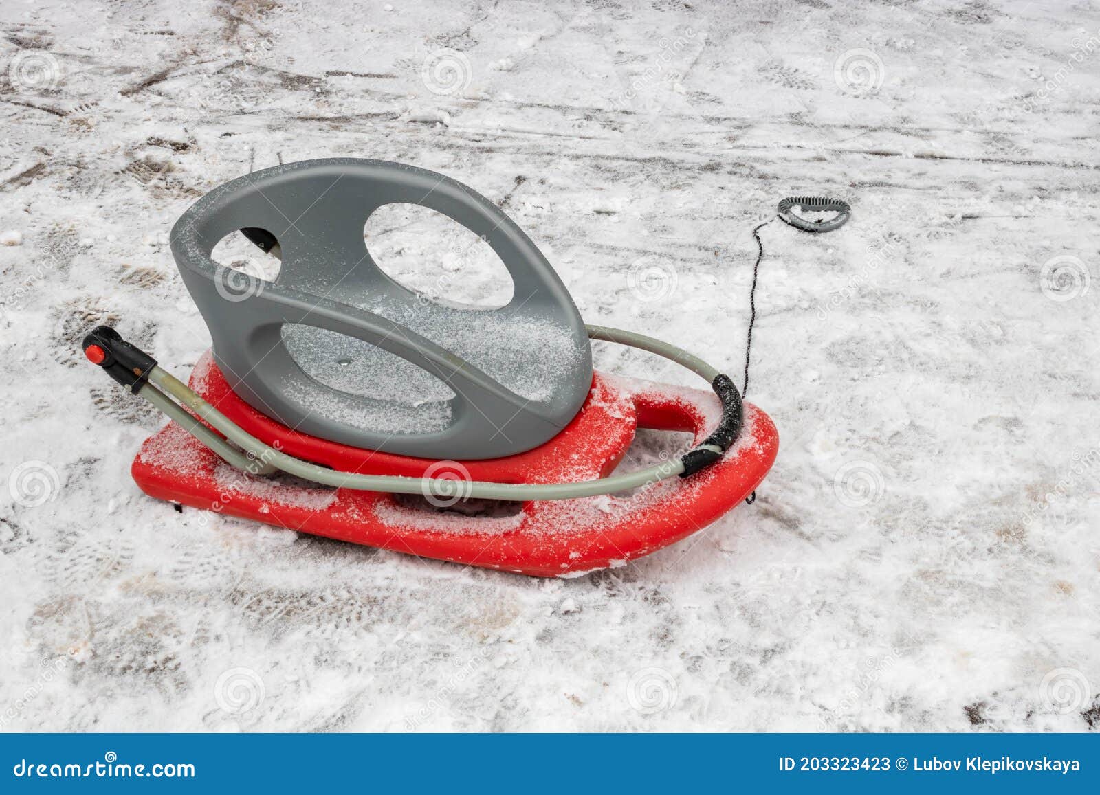 Red-gray Plastic Snow Sled on the Snow on the Road Stock Image - Image ...