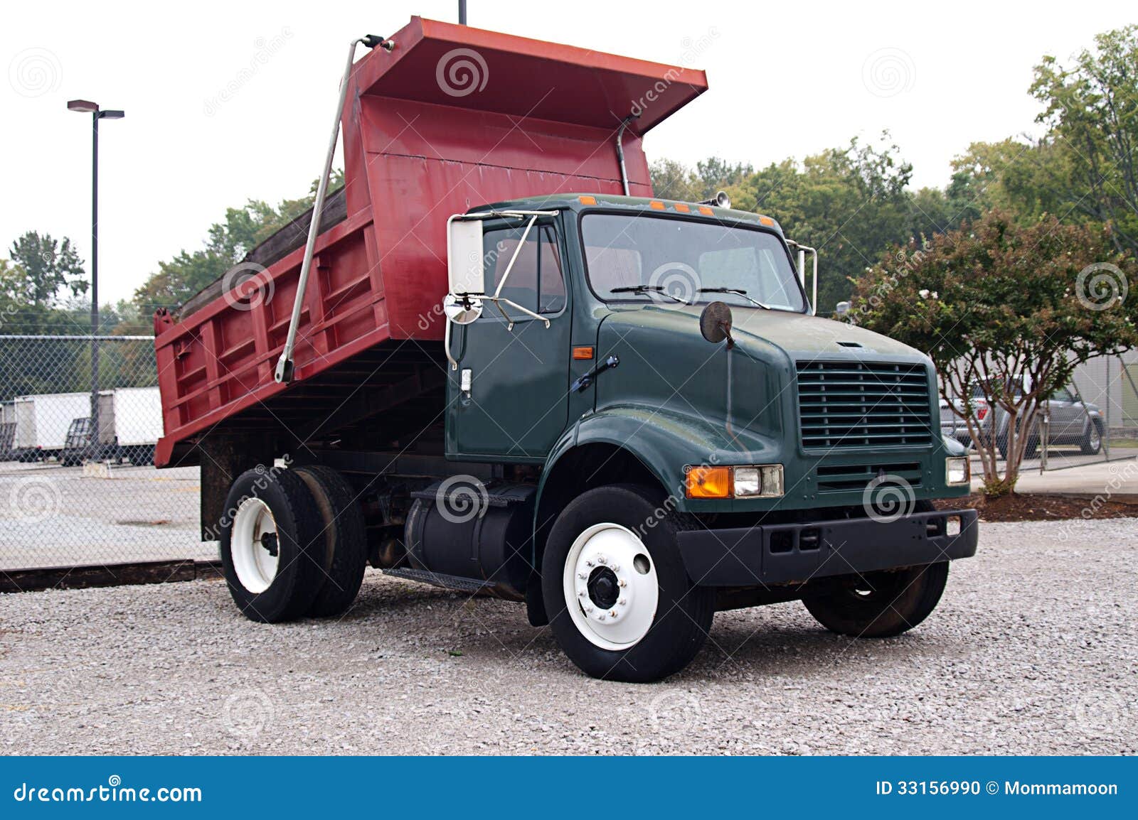 One Big Old Green Dump Truck Stands On A Gray Asphalt Road Stock ...
