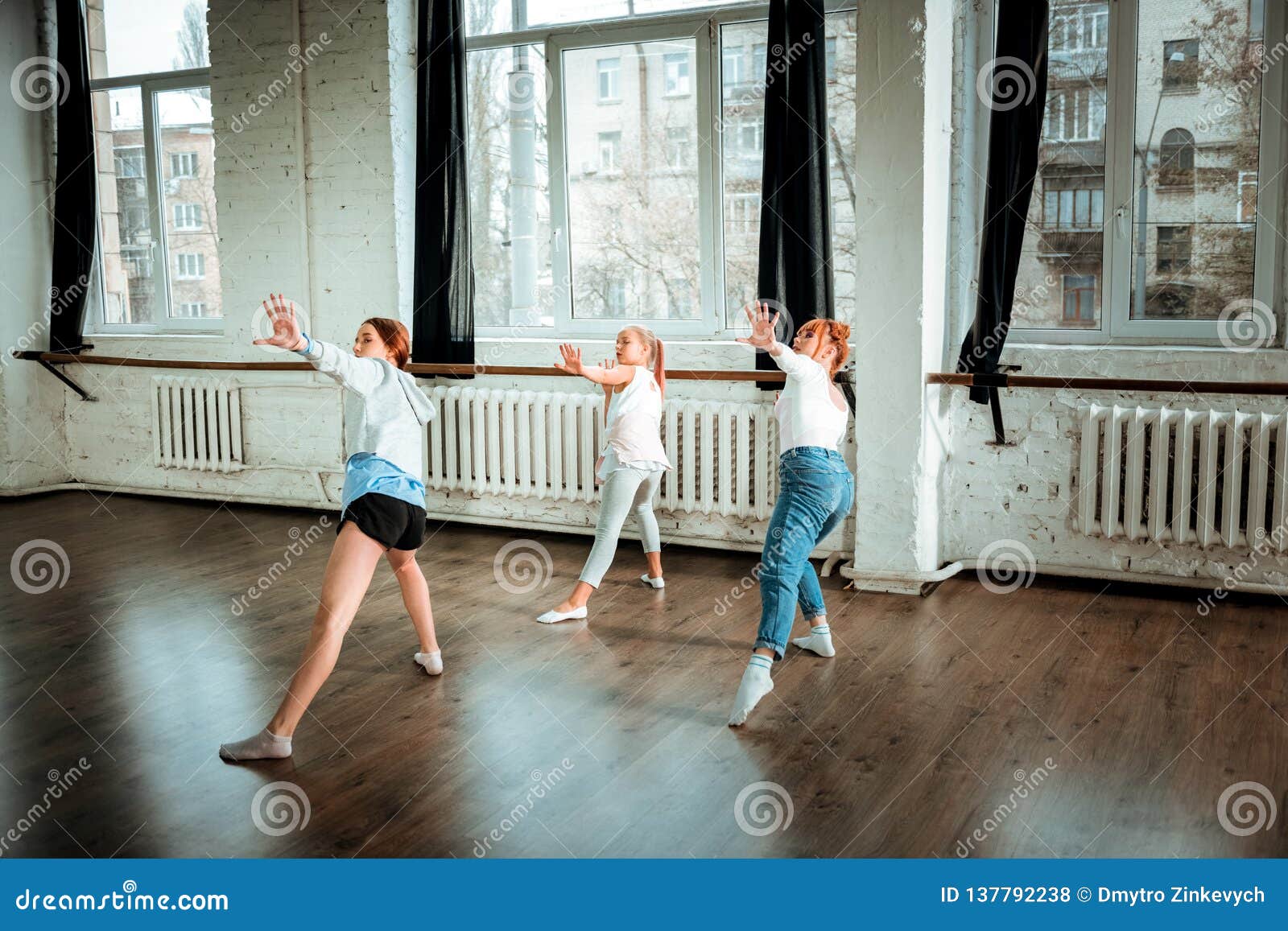 Red-haired Dance Teacher in Blue Jeans and Her Students Exercising in ...