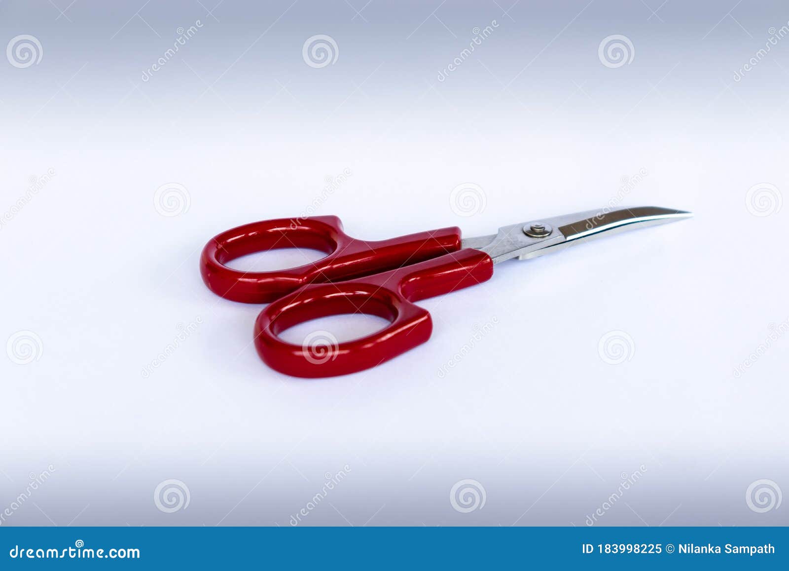 Red Handle Silver Curved Scissor on a White Paper Stock Image - Image ...