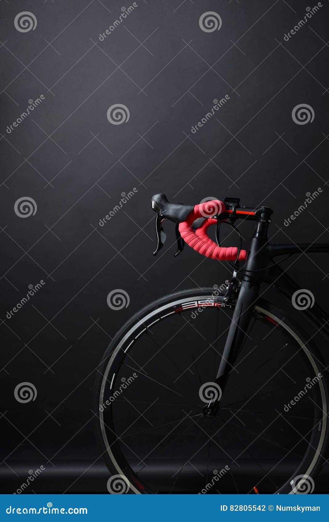 Red Handlebar and Black Wheel of a Race Bicycle on Black Background ...