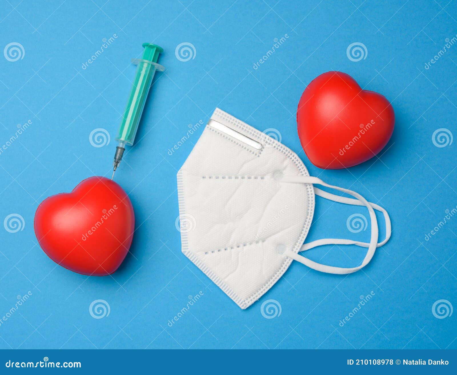 Red Heart and a Stuck Needle of a Plastic Syringe into it, White Mask ...