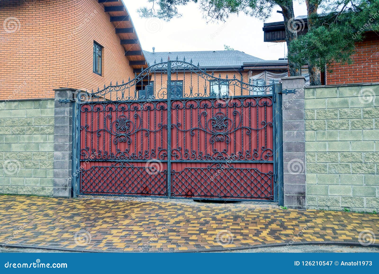 Red Iron Gate with a Wrought-iron Pattern with a Stone Fence in the ...