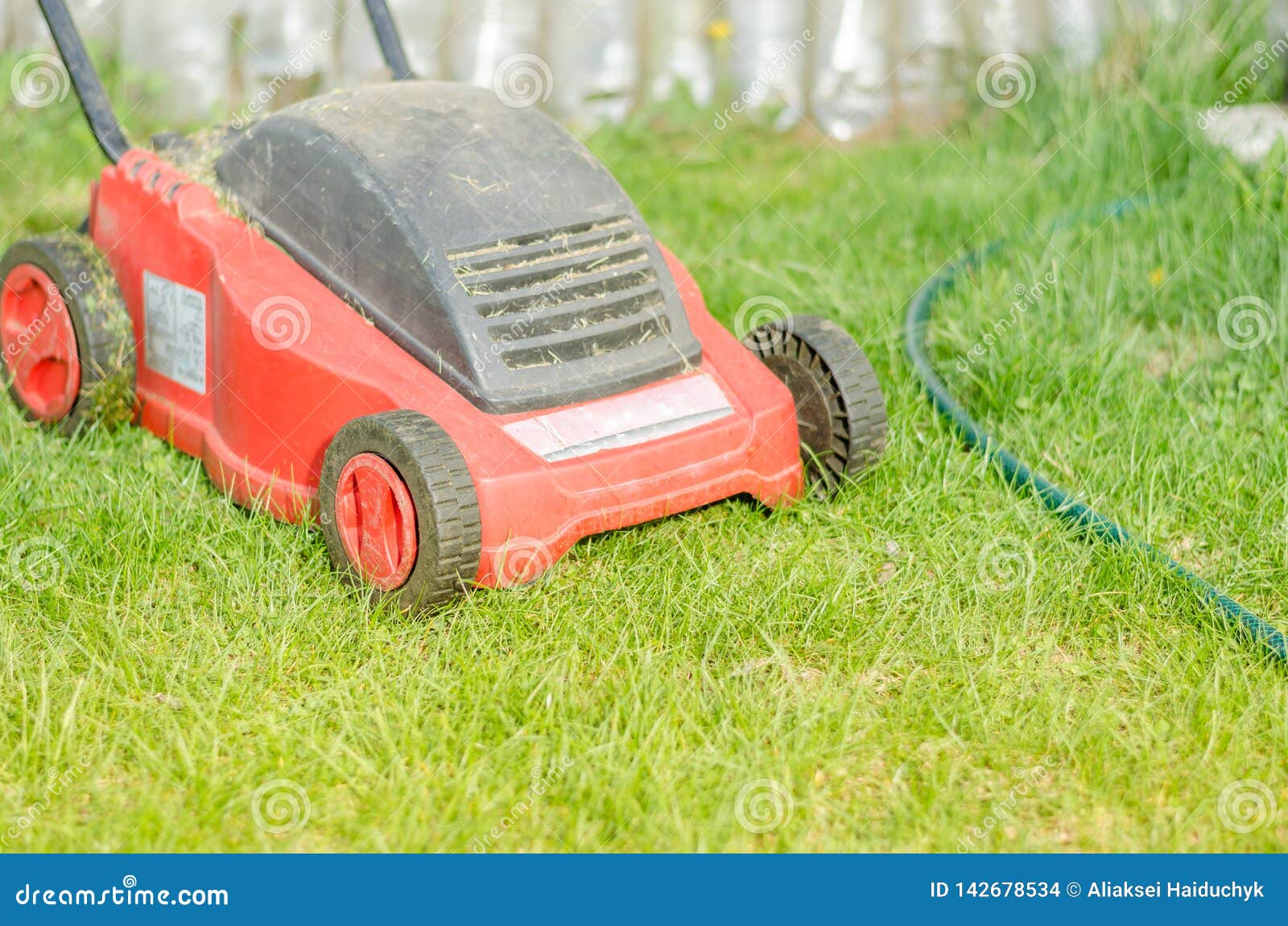 Red Lawn Mower Cutting Green Grass/red Lawn Mower on a Green Lawn Stock ...