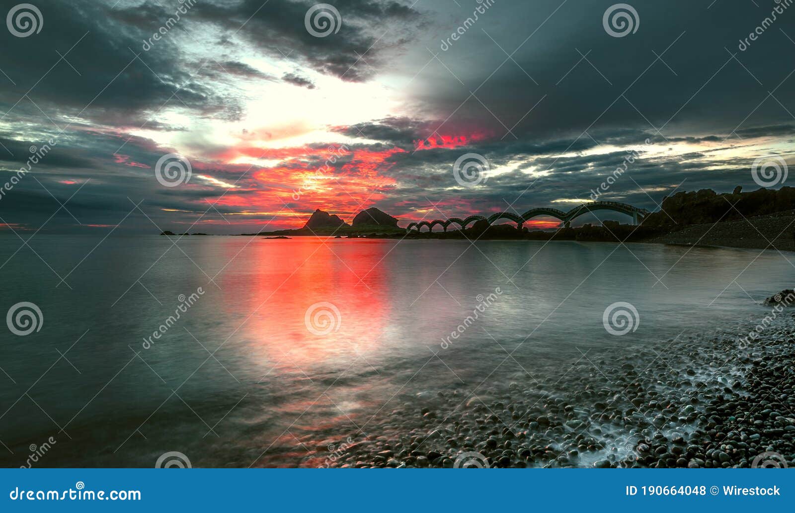 Red Light Falling on the Sea with Pebbles in the Beach Stock Photo ...