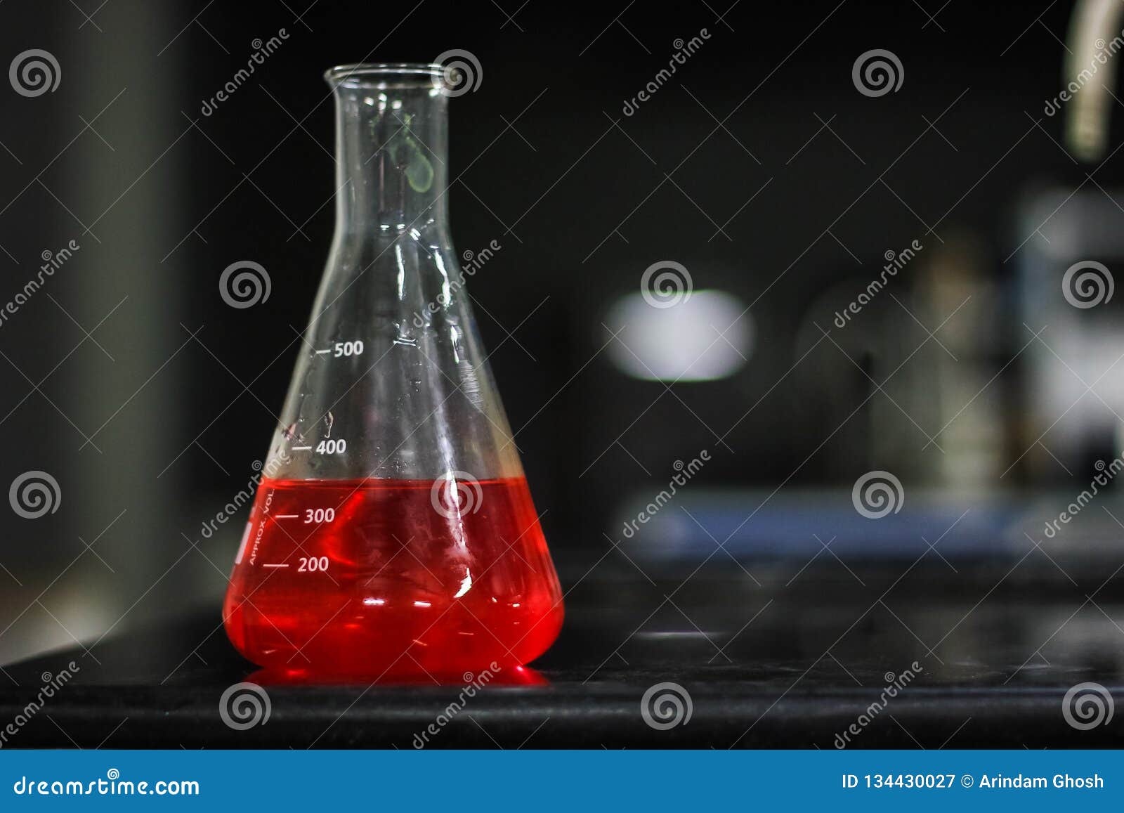 Red Liquid in a Glass Conical Flask on a Black Granite Table in Dark ...