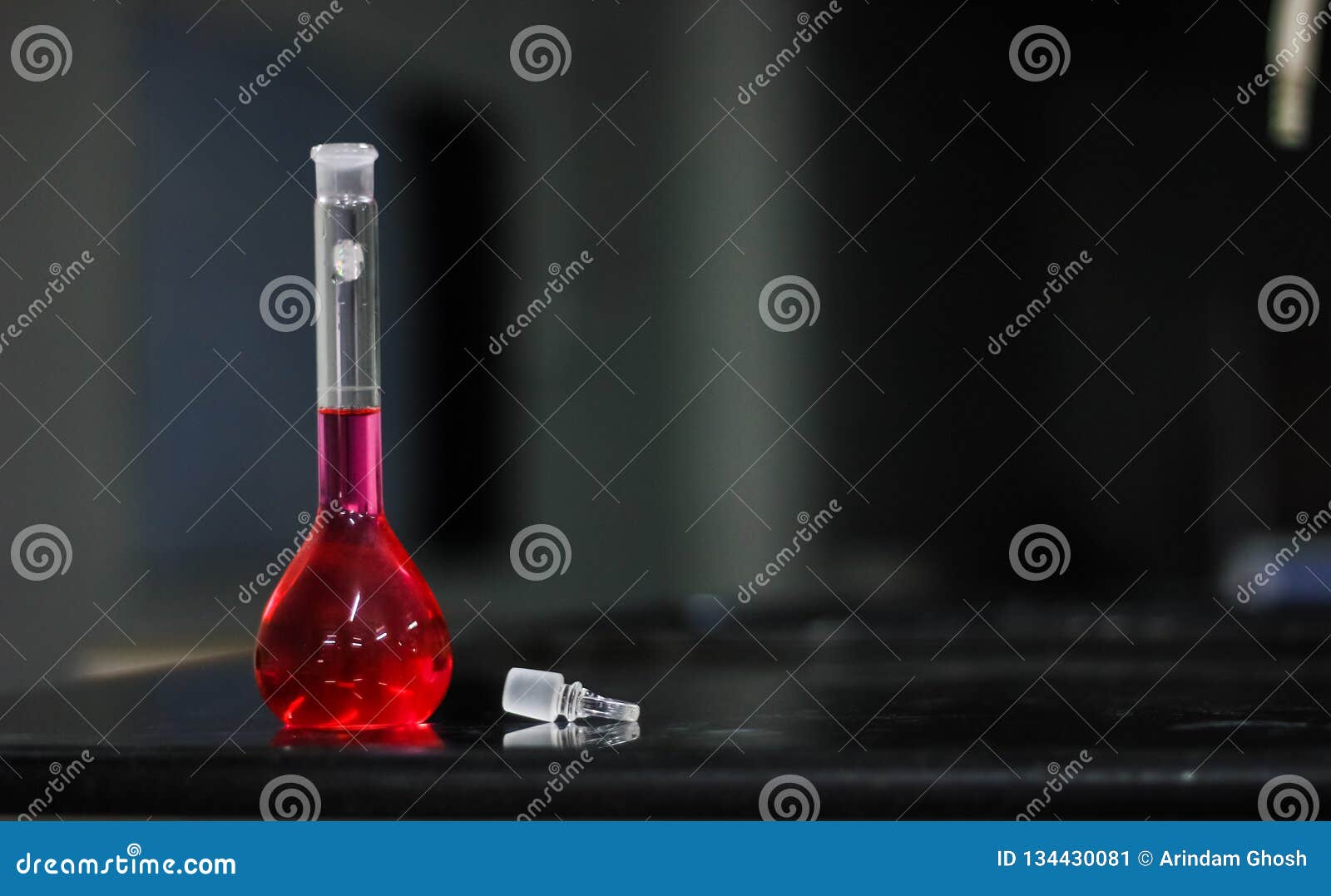 Red Liquid in a Round Bottomed Flask on a Black Granite Table in Dark ...