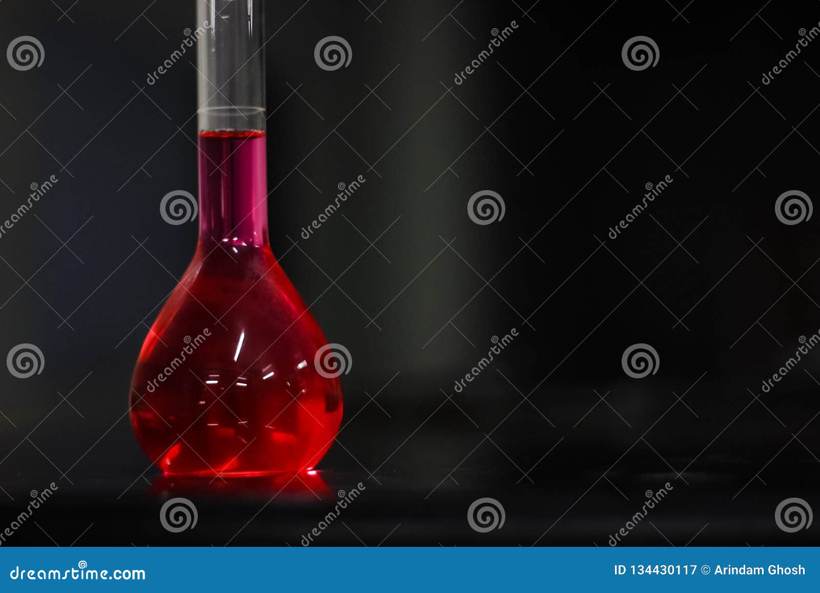 Red Liquid in a Round Bottomed Flask on a Black Granite Table in Dark ...