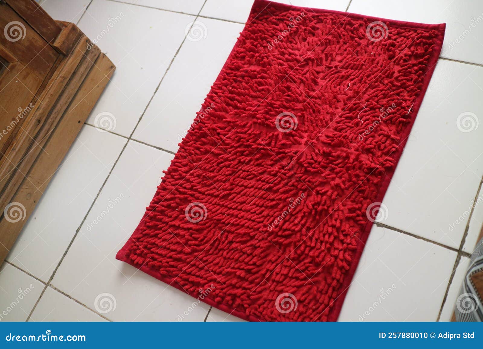 Red mat on the tiled floor stock photo. Image of cloth - 257880010