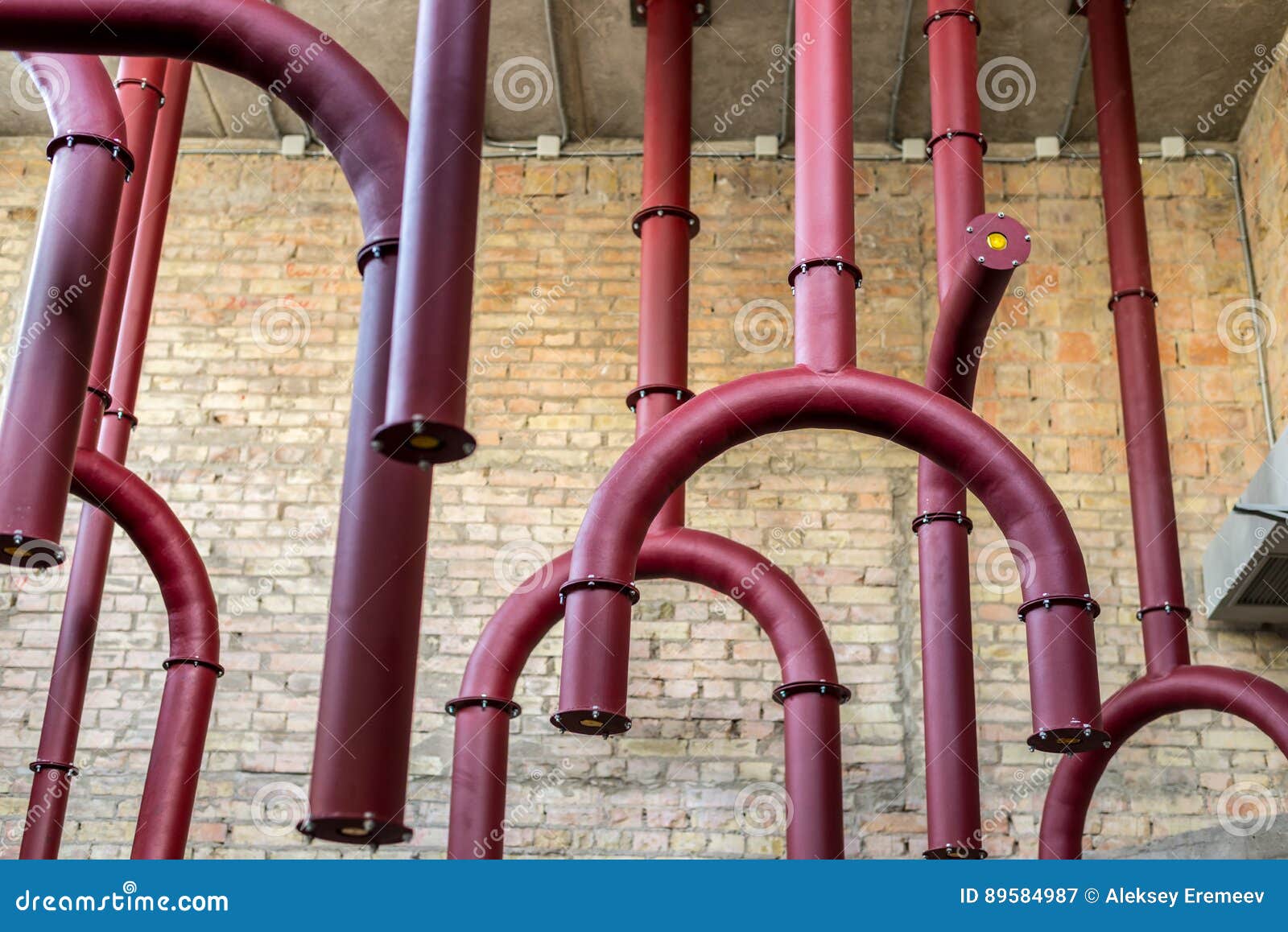 Red Metal Pipes Hanging from the Ceiling Against a Brick Wall ...