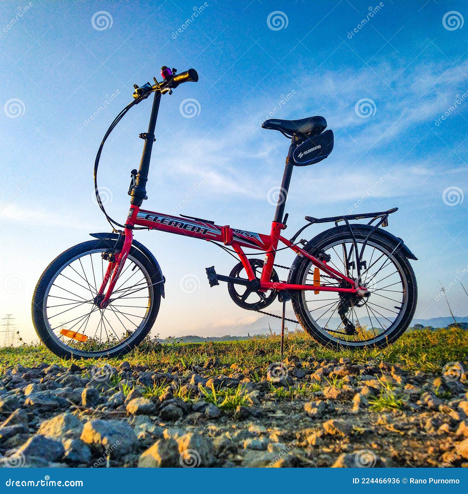 Red Mini Bicycles in the Fields with a Bright Blue Sky and White Clouds ...